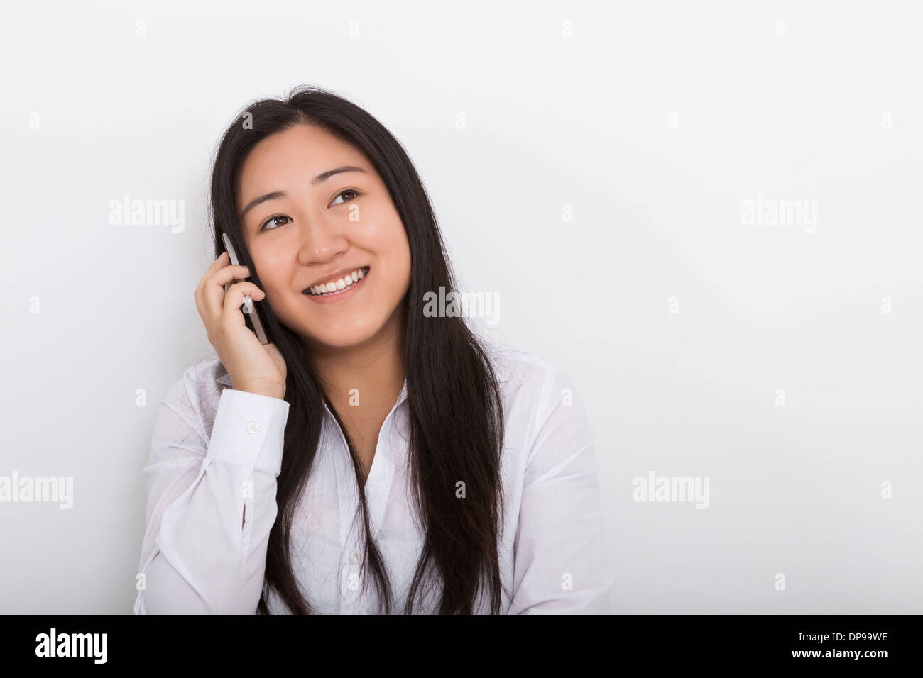 Happy woman answering cell phone against white background Stock Photo ...