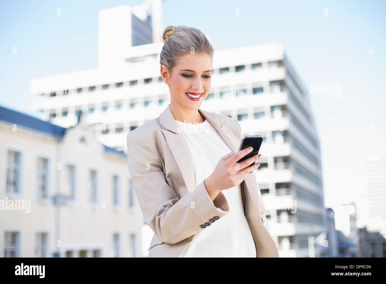 Cheerful attractive businesswoman sending a text message Stock Photo ...