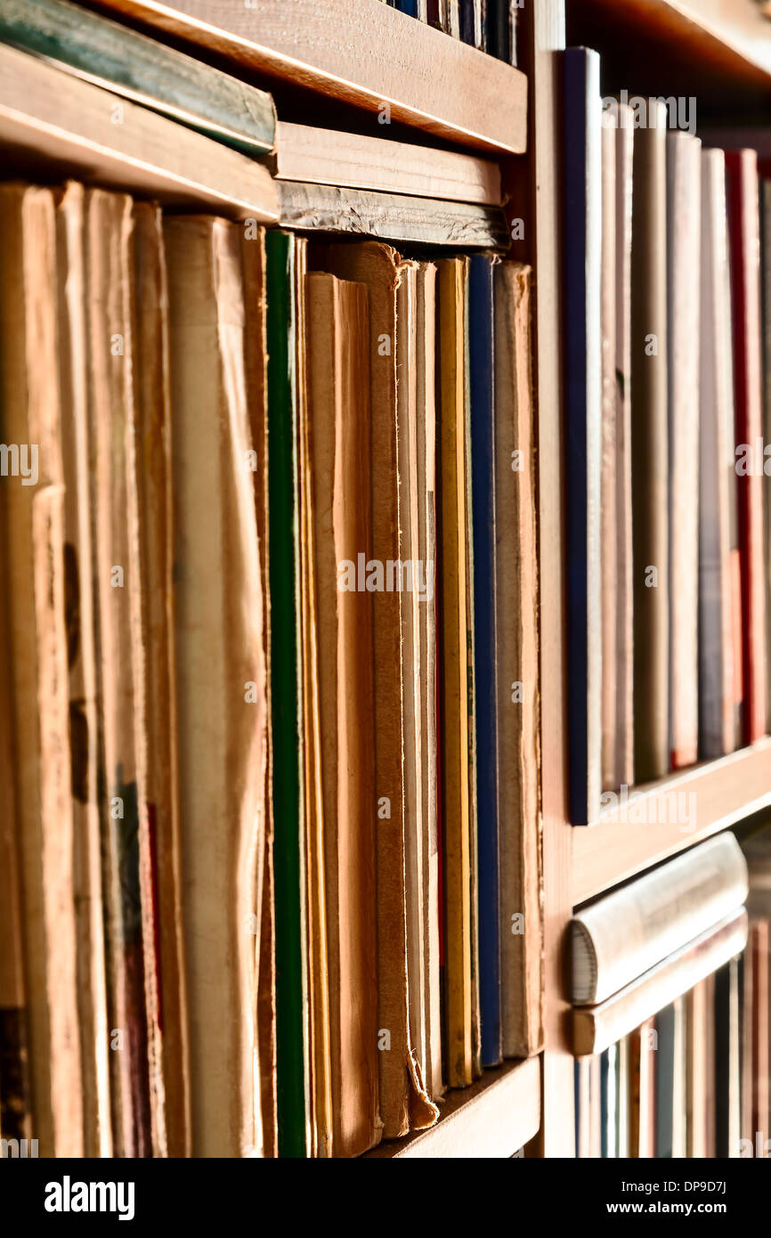 Books on the shelves in the library shown closeup Stock Photo - Alamy