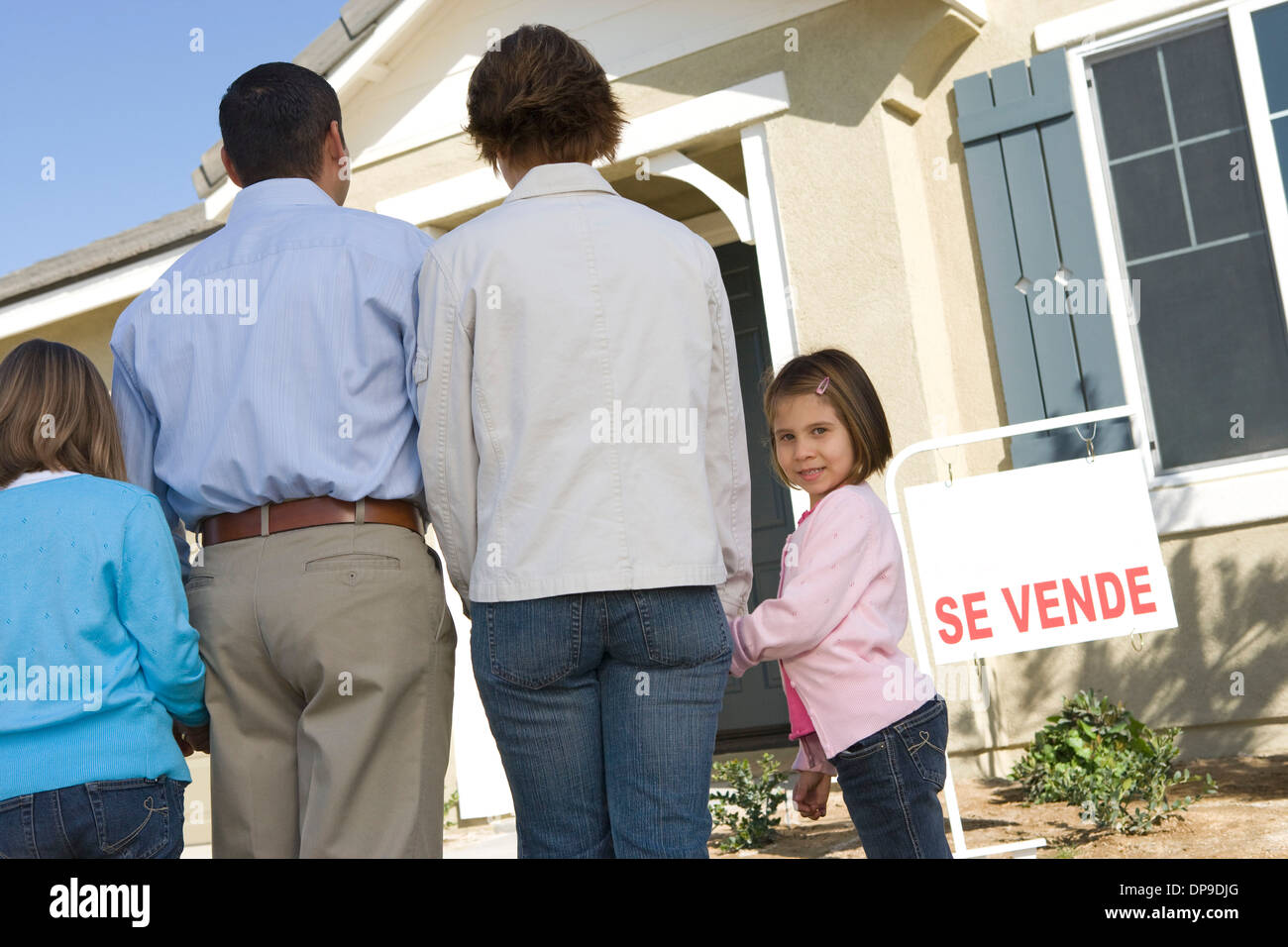 Family with two children (6-8) in front of new house back view Stock ...