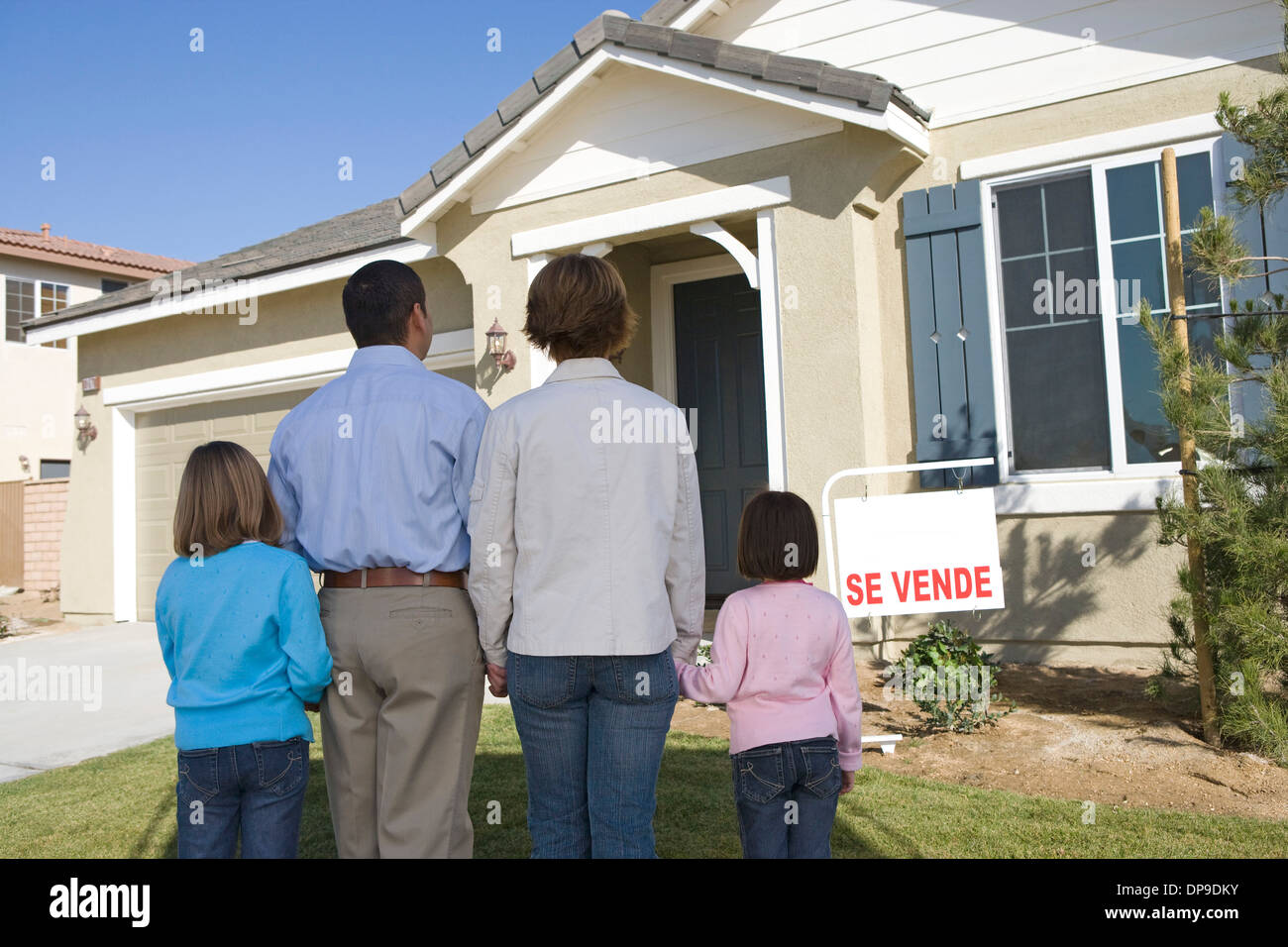 Family with two children (6-8) in front of new house back view Stock ...