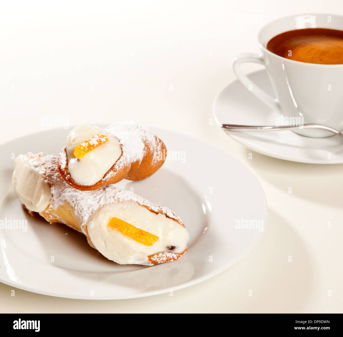 A couple of sicilian cannoli with a coffee cup Stock Photo - Alamy