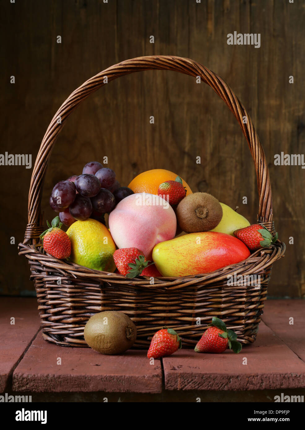 still life wicker basket with fruit on a wooden table Stock Photo - Alamy