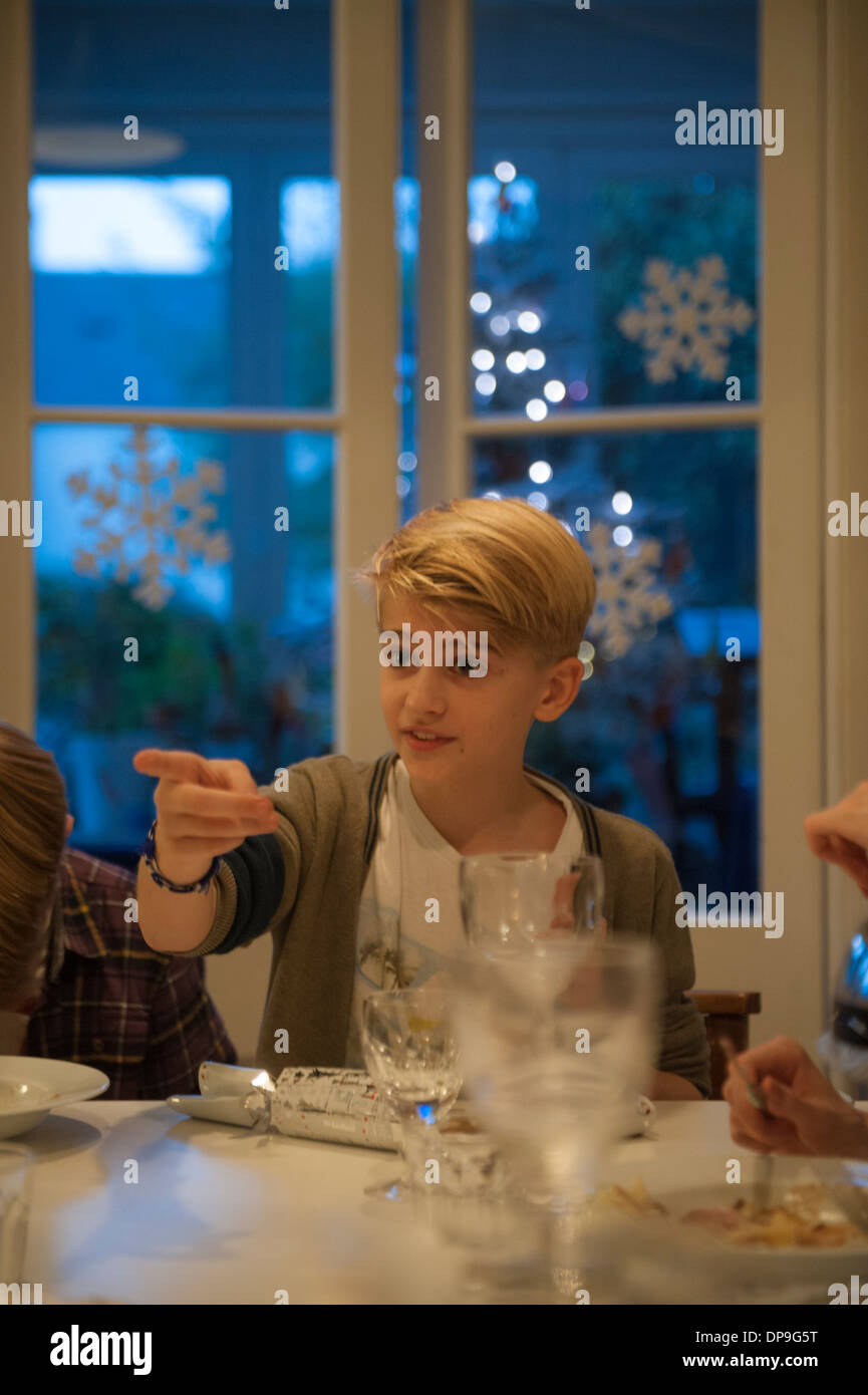 A young boy looks happy at a Christmas lunch with a Christmas tree ...