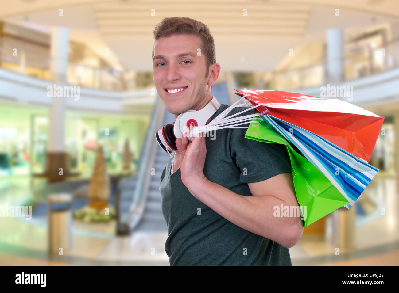 Casual young man with shopping bags in a shopping mall Stock Photo - Alamy