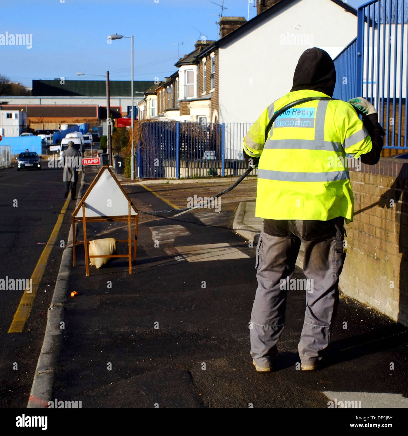 Construction worker pulling on a long power cable Stock Photo - Alamy