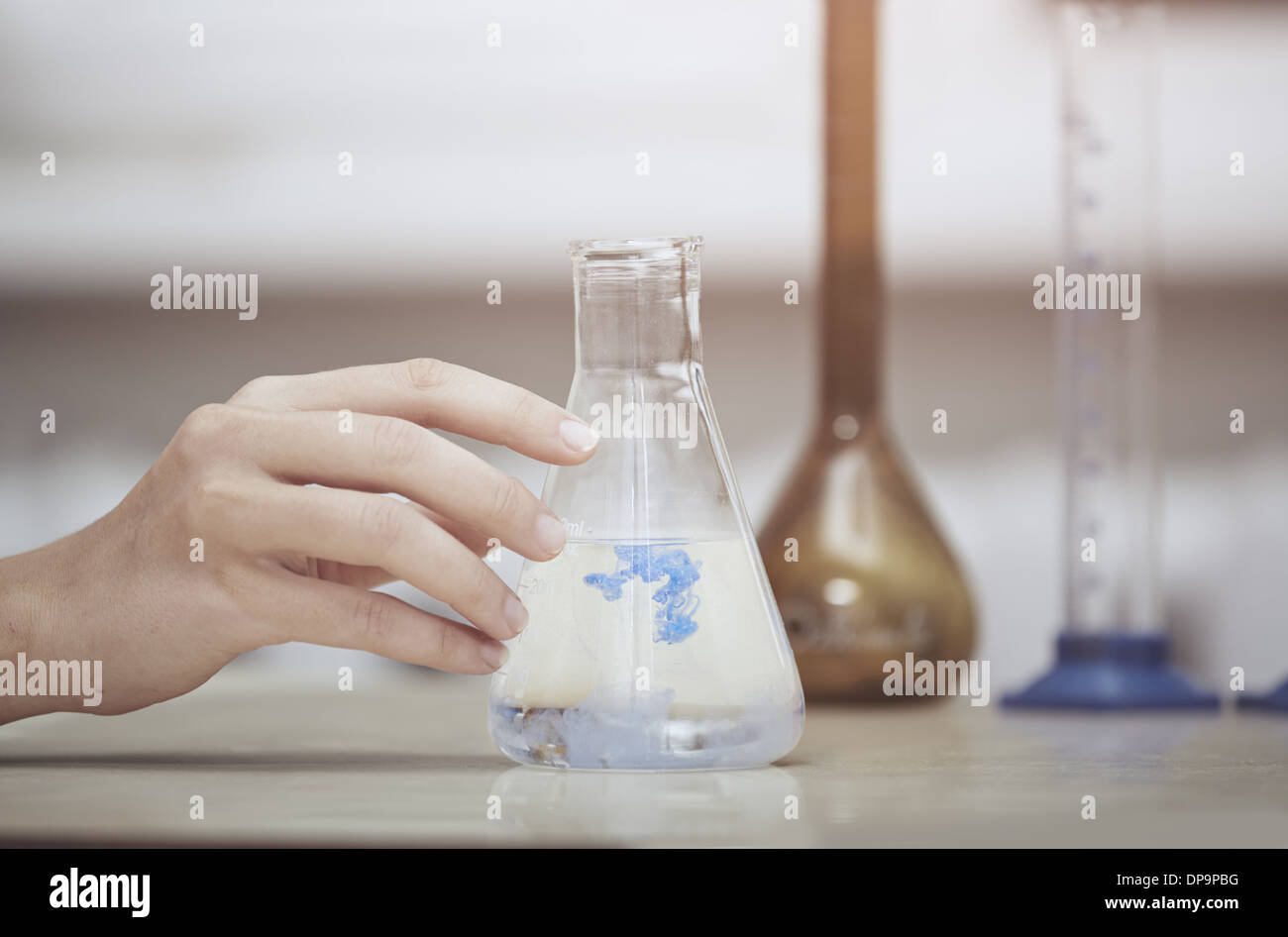 Hand of laboratory technician holding flask with chemical Stock Photo ...
