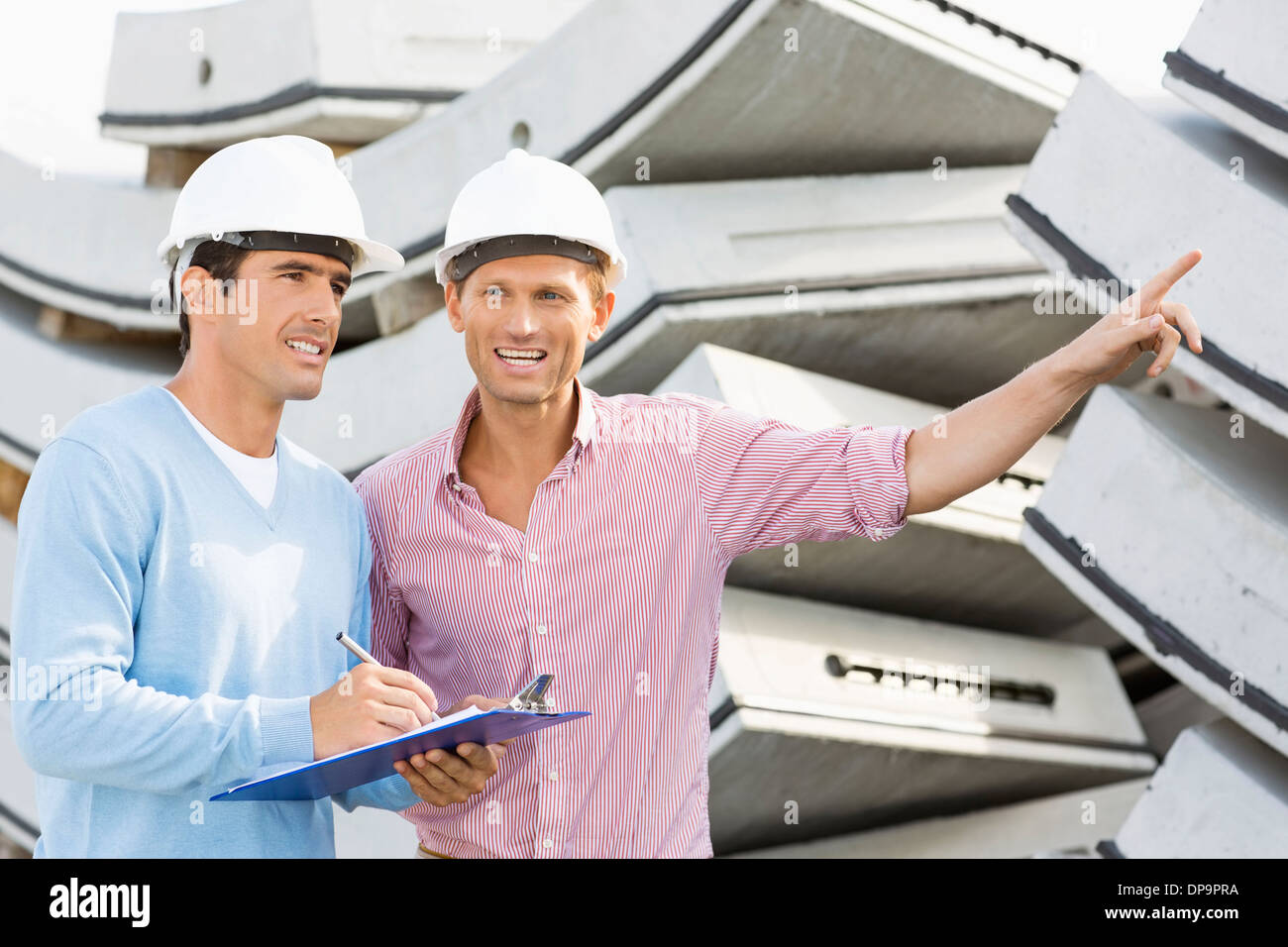 Smiling architects inspecting stock at site Stock Photo - Alamy