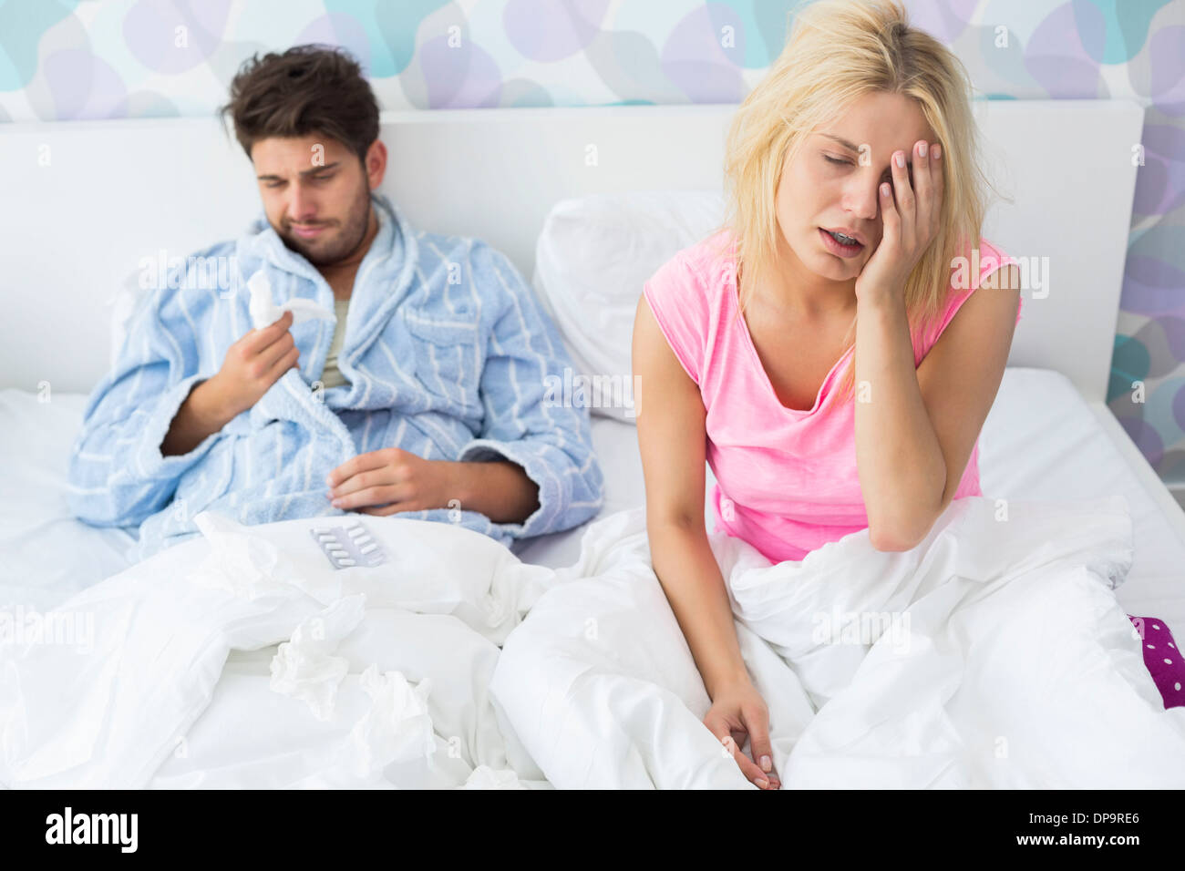 Irritated sick couple on bed at home Stock Photo - Alamy