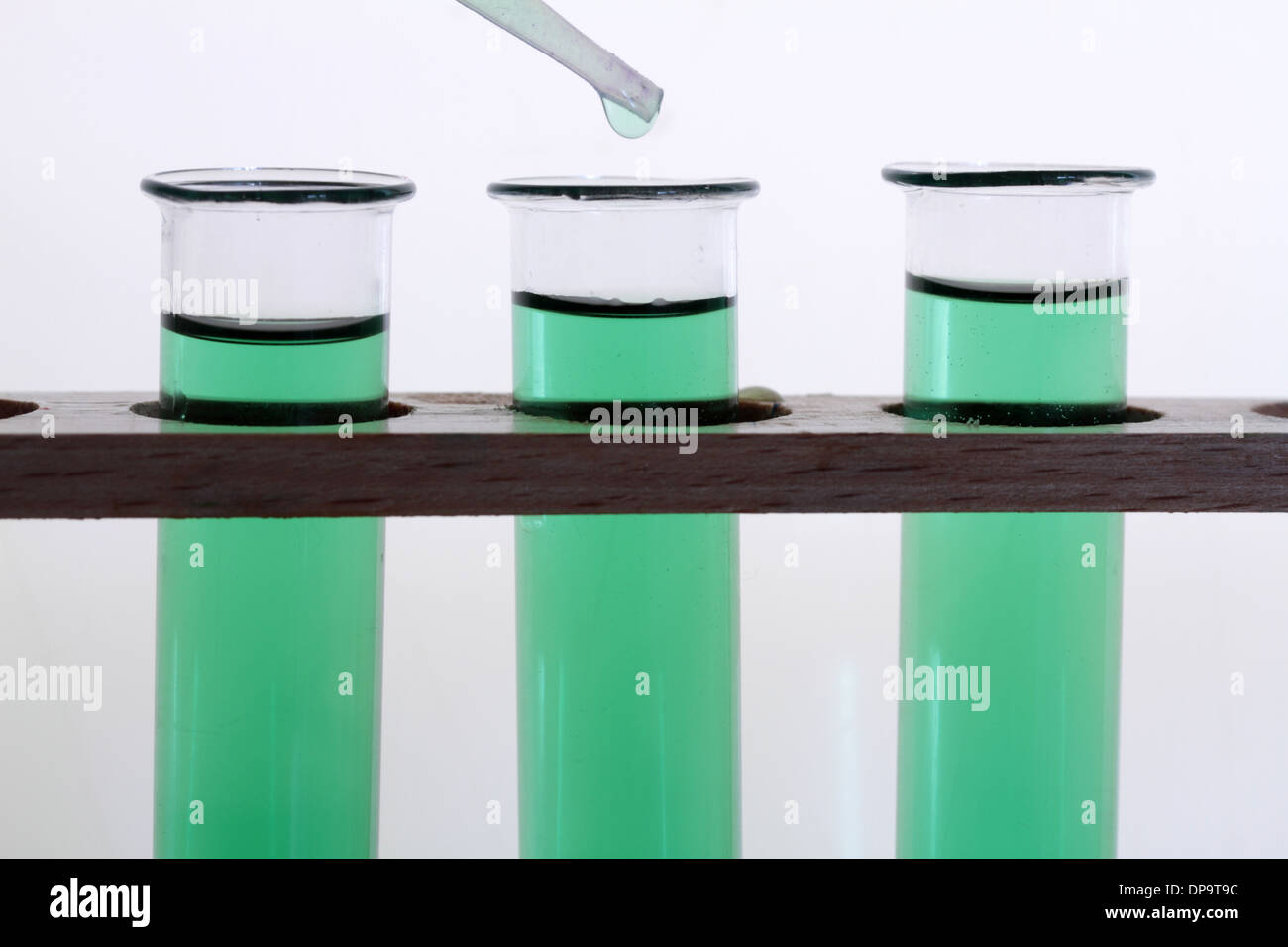 glass tubes with green chemistry liquid an a pipette with a drop of ...