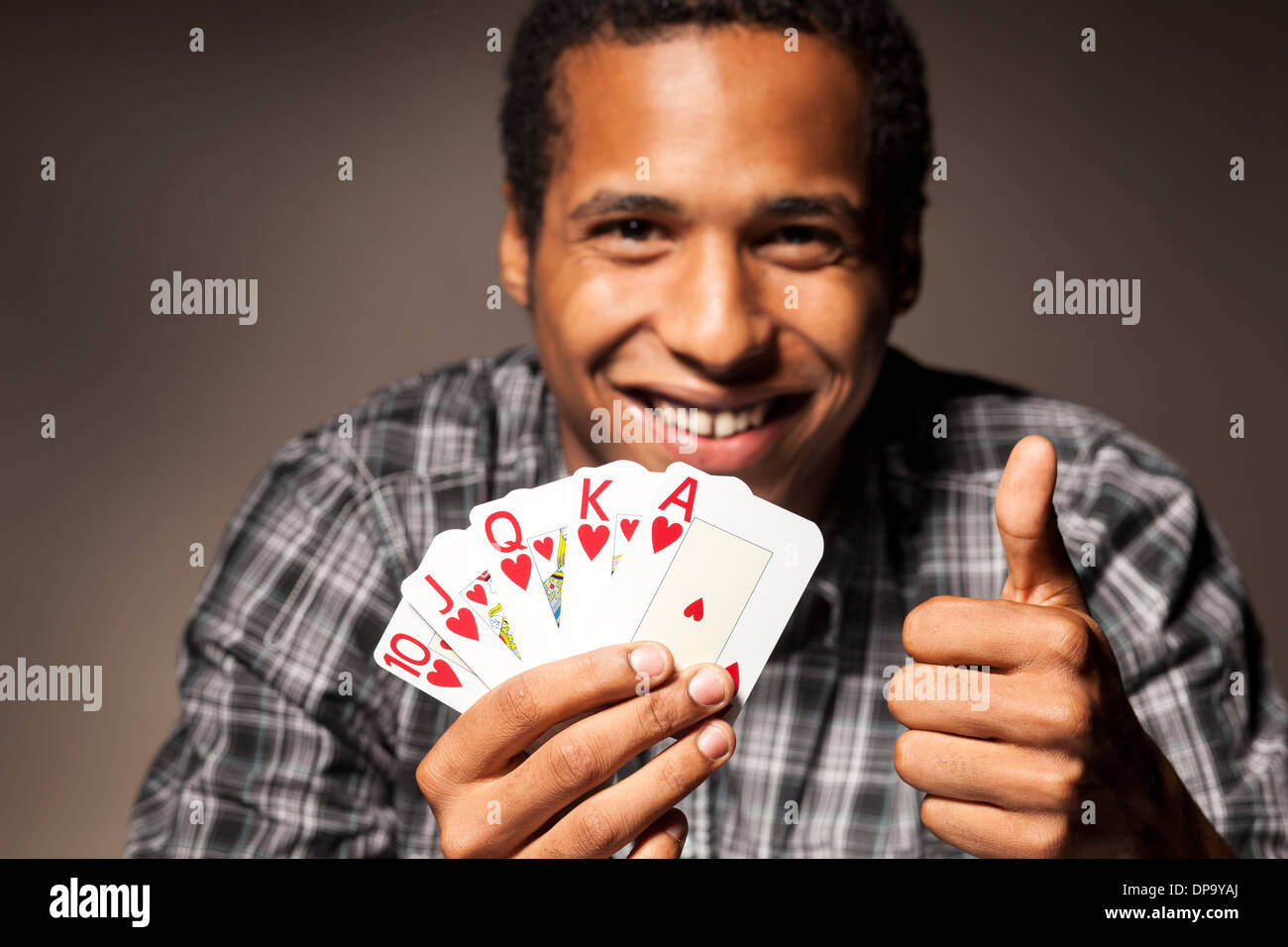 african young man holds the winning combination of poker cards Stock ...