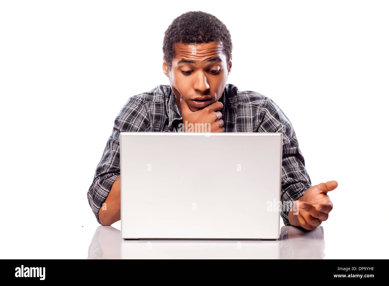dark-skinned young man puzzled looking at his laptop Stock Photo - Alamy