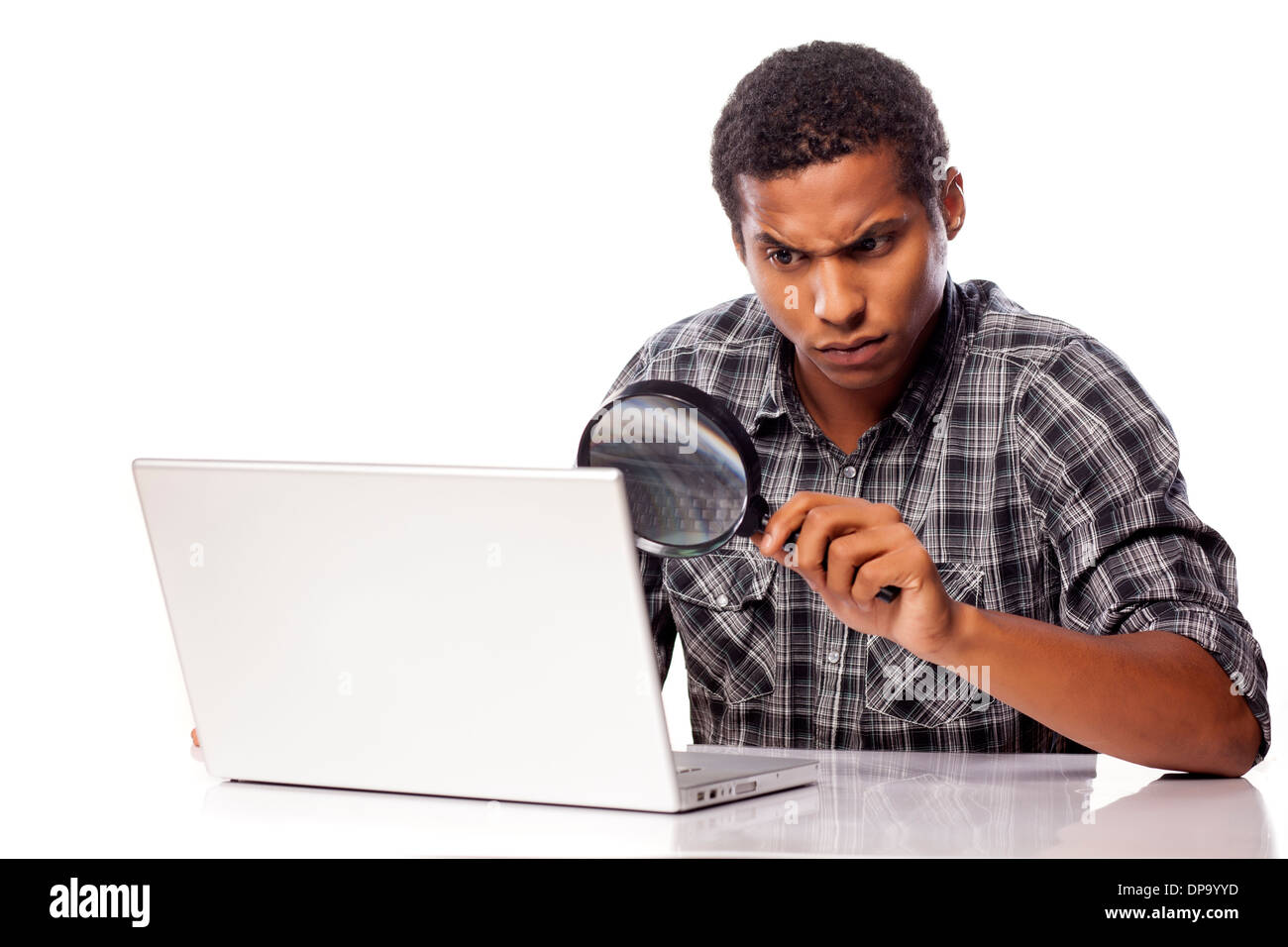 african man looking through a magnifying glass on his laptop Stock ...