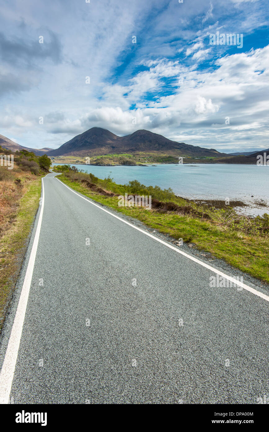 A narrow road in Scotland on the Isle of Skye with the Cuillins in the ...