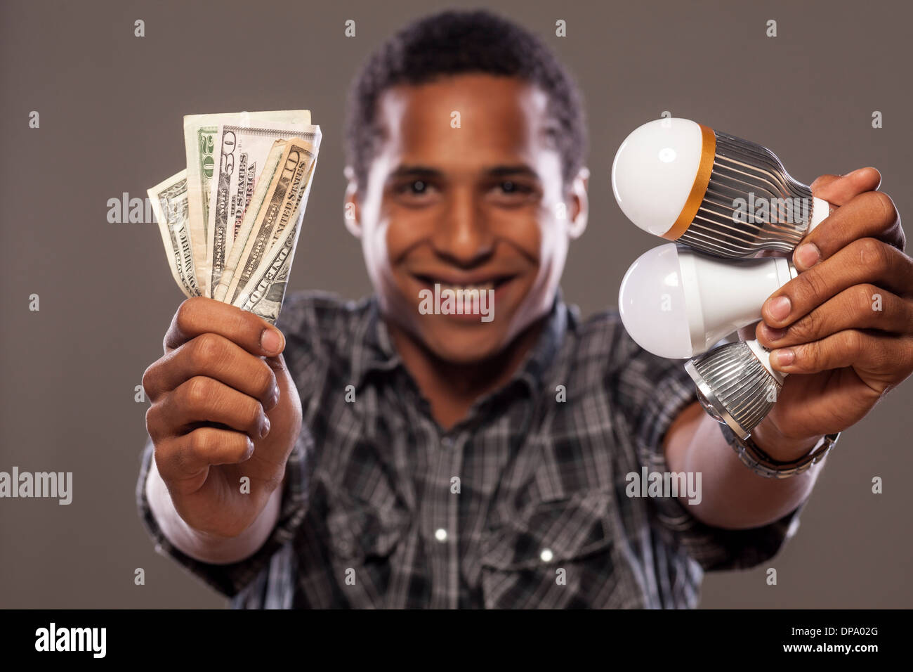 smiling man showing money that is a saving by using LED bulbs Stock ...