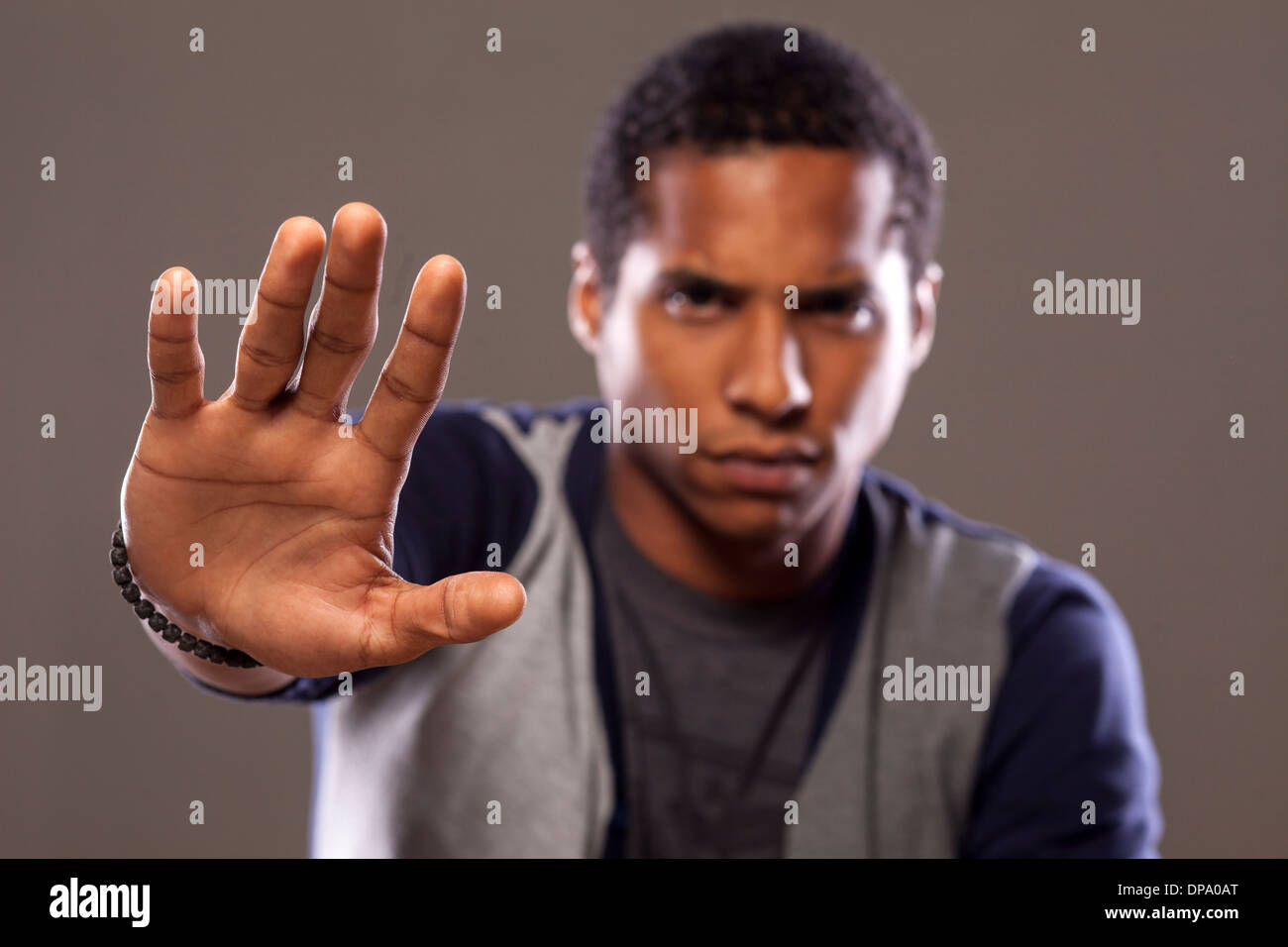 dark-skinned young man showing stop sign with his hand Stock Photo - Alamy