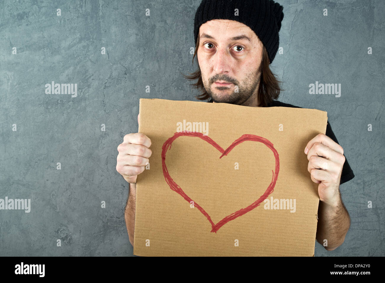 Man holding cardboard paper with heart shape drawing as Valentines day ...