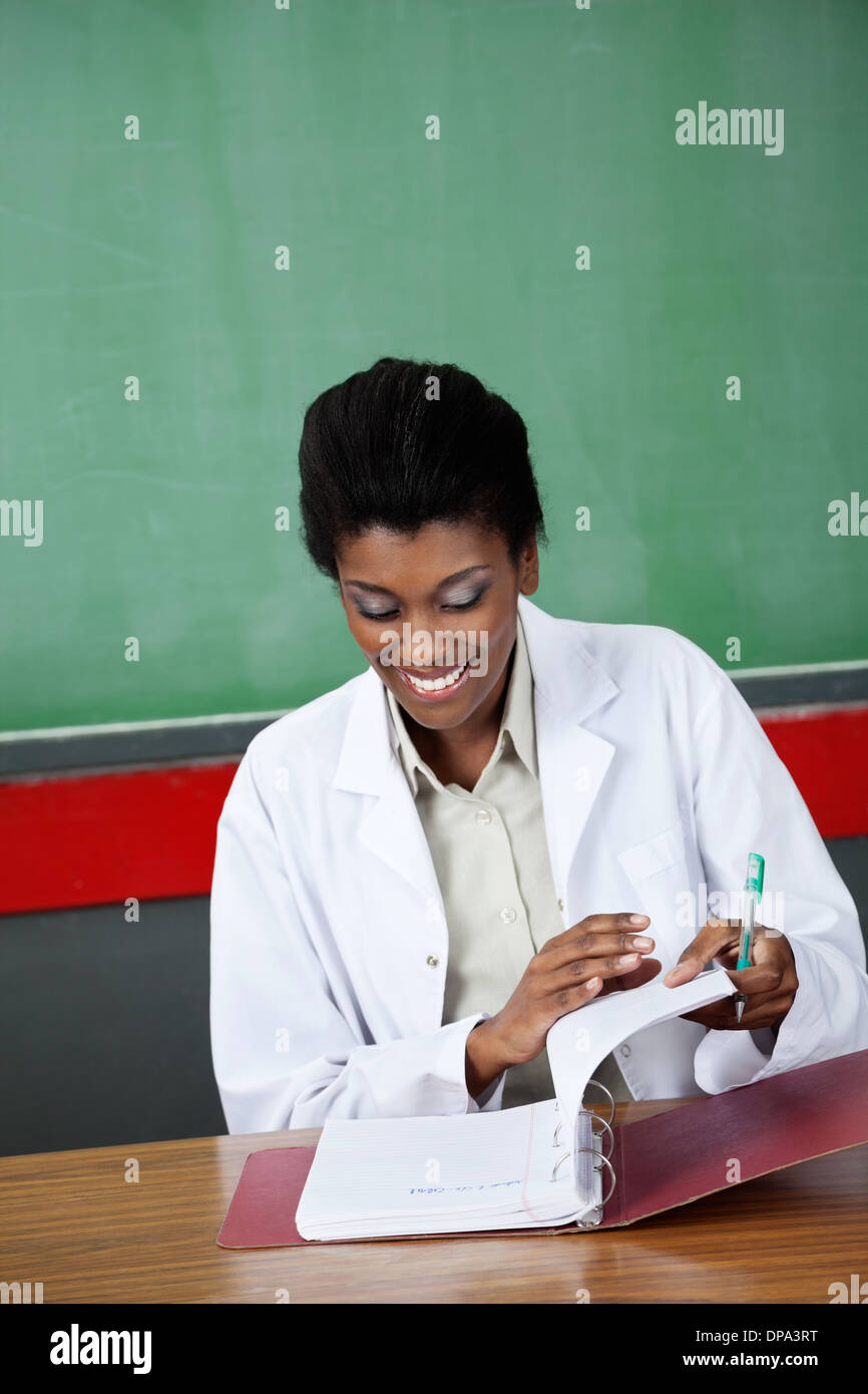 Teacher Reading Paper In Binder At Desk Stock Photo - Alamy