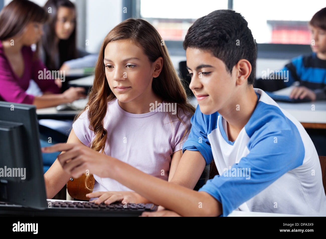 Boy With Female Friend Pointing At Computer Screen Stock Photo - Alamy