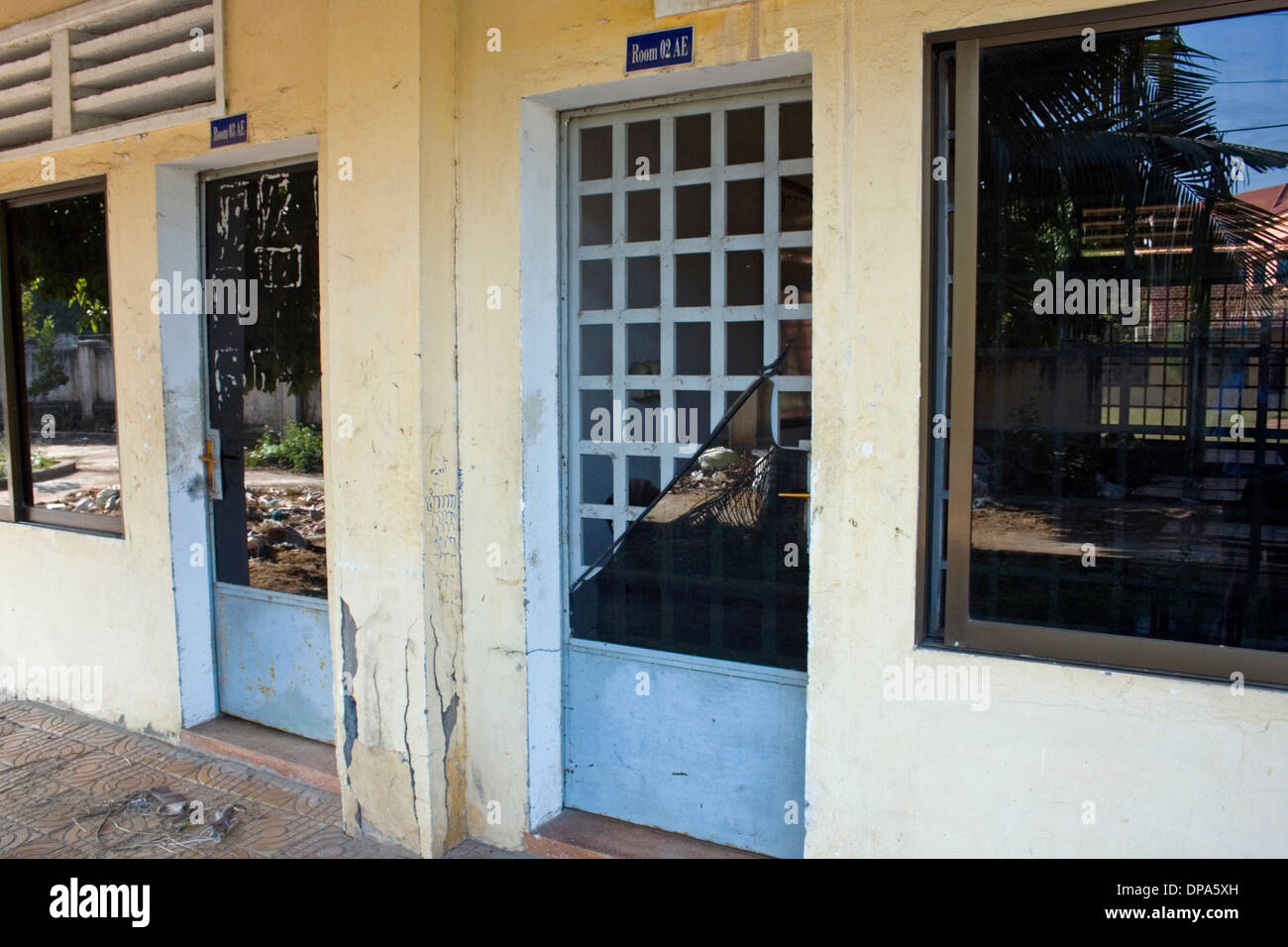 A dilapidated classroom with a broken door window stands vacant at the ...