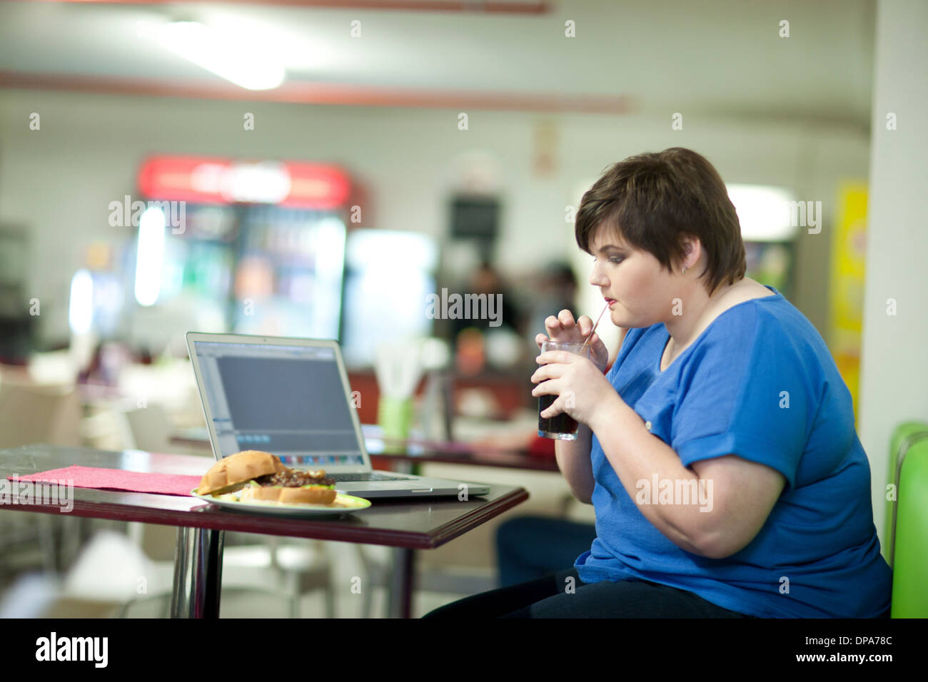 Young woman drinking coke in cafe Stock Photo - Alamy