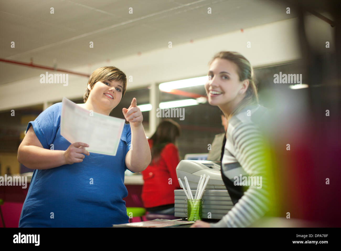 Young woman ordering from menu in cafe Stock Photo - Alamy