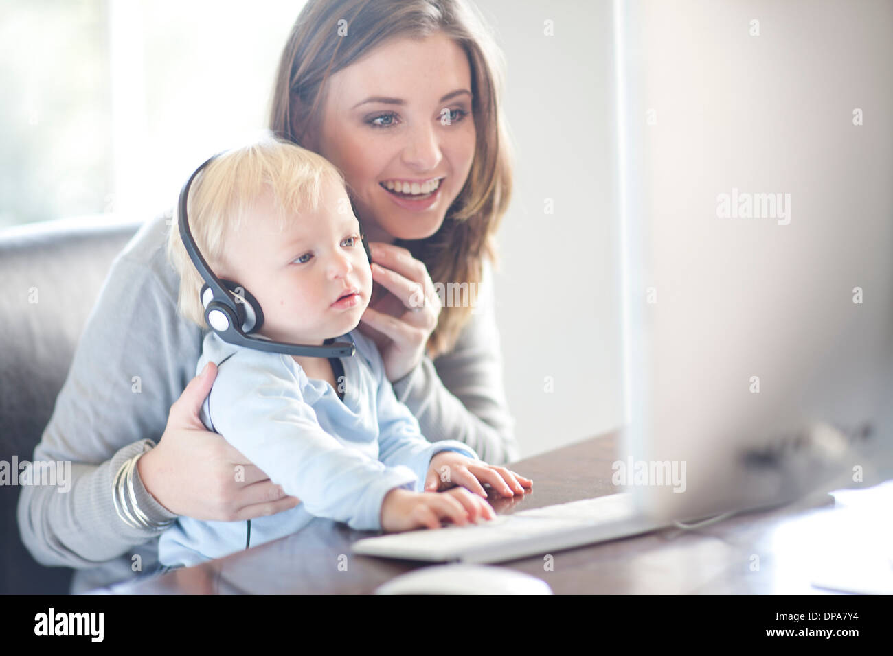 Mother and baby boy looking at computer screen Stock Photo - Alamy