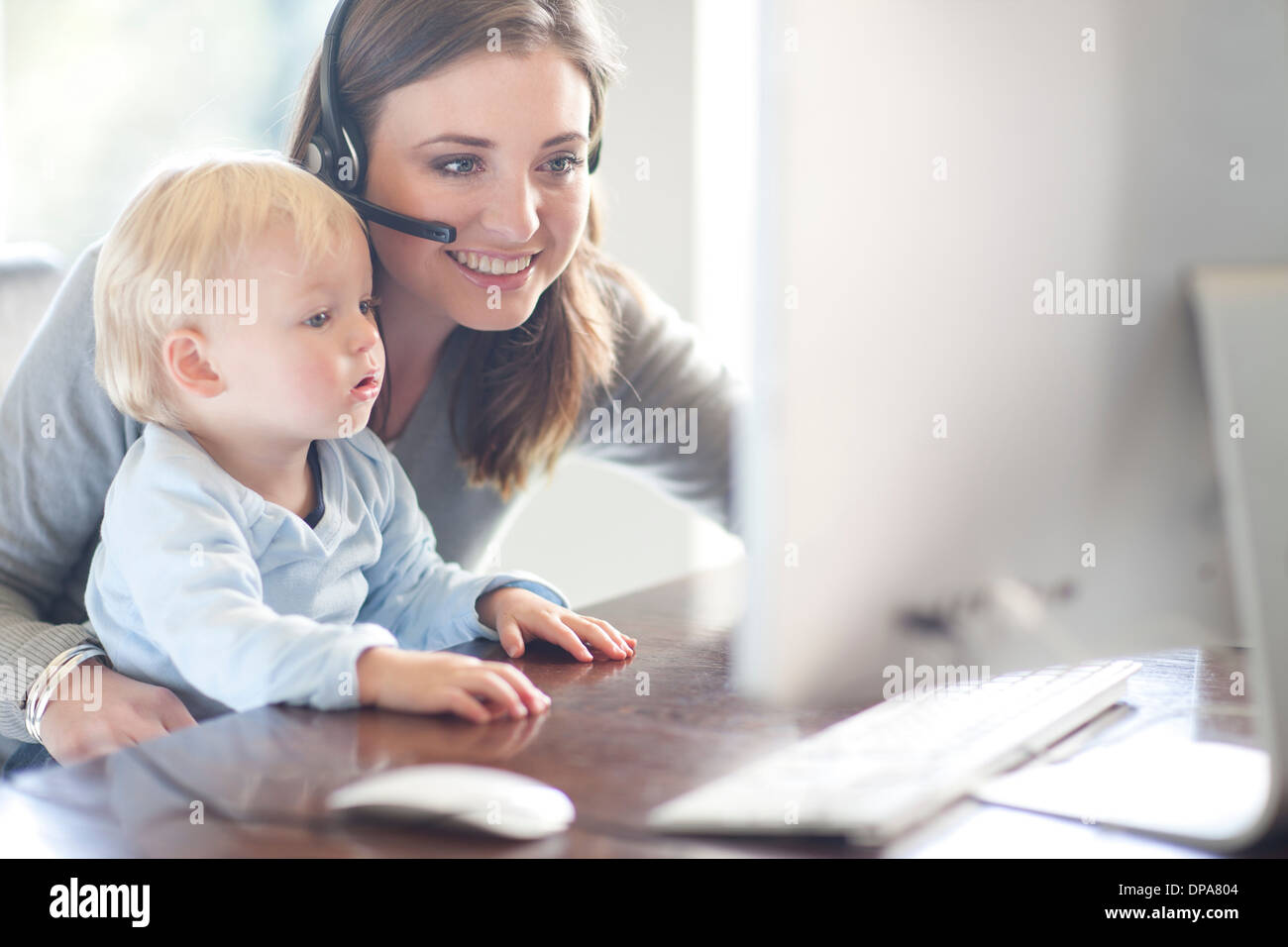 Mother and baby boy looking at computer Stock Photo - Alamy