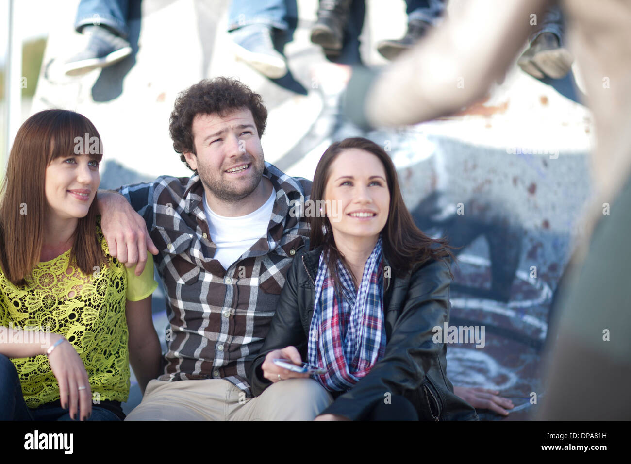 Young adult friends in front of graffiti Stock Photo - Alamy