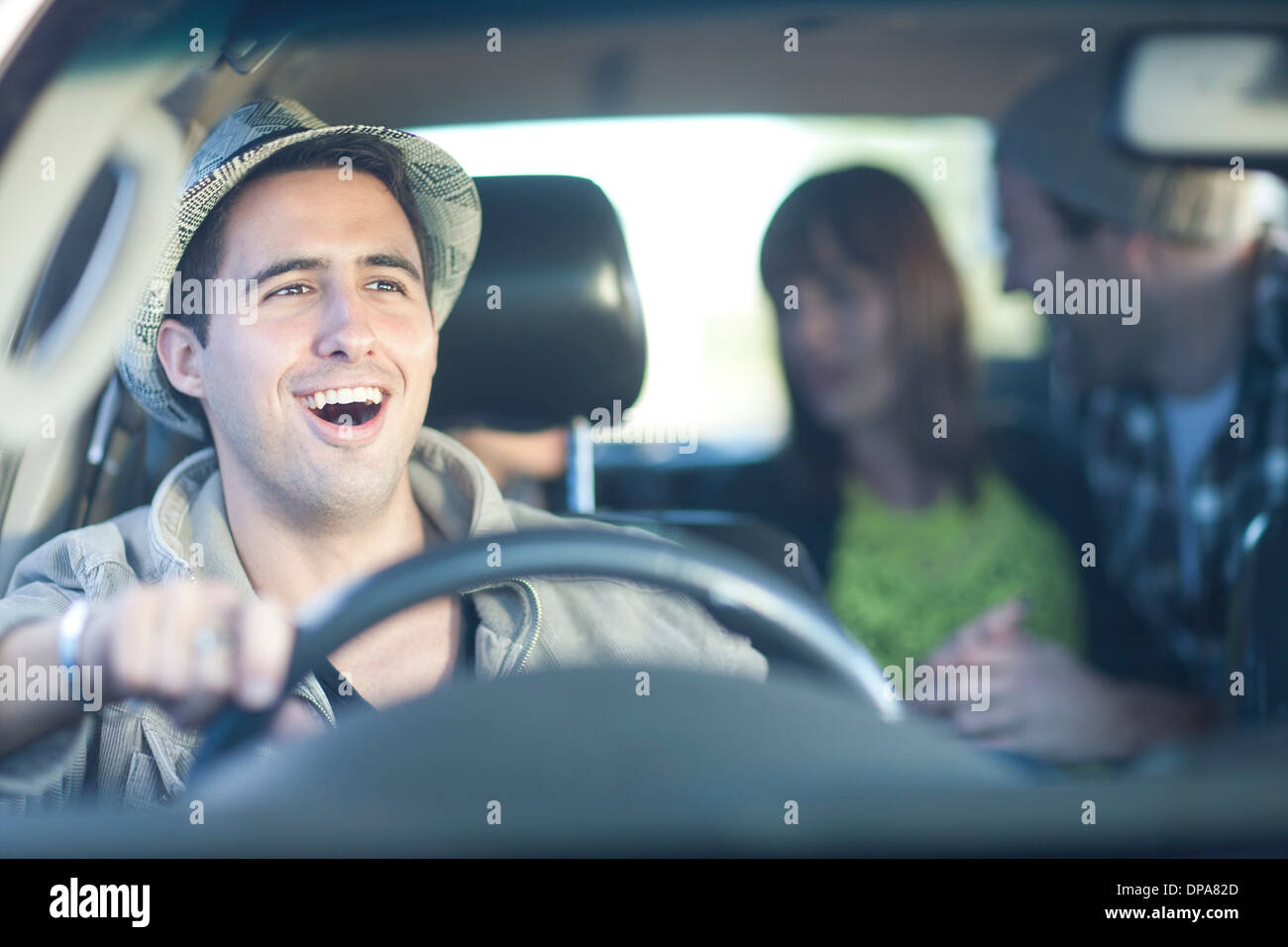 Young adult friends driving in car Stock Photo - Alamy