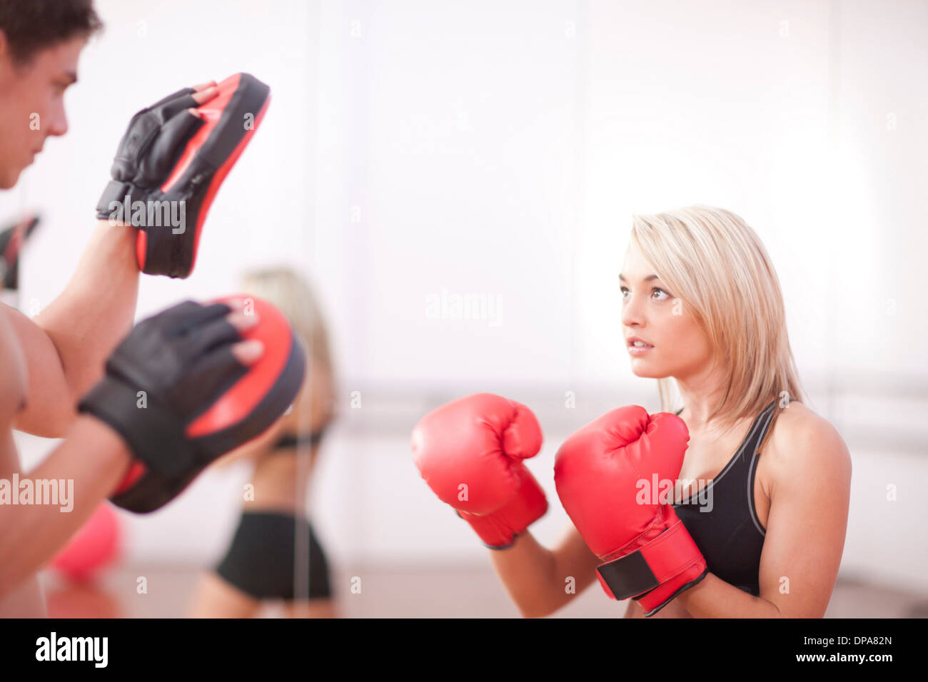 Young female boxer is standing and wearing gloves hi-res stock ...
