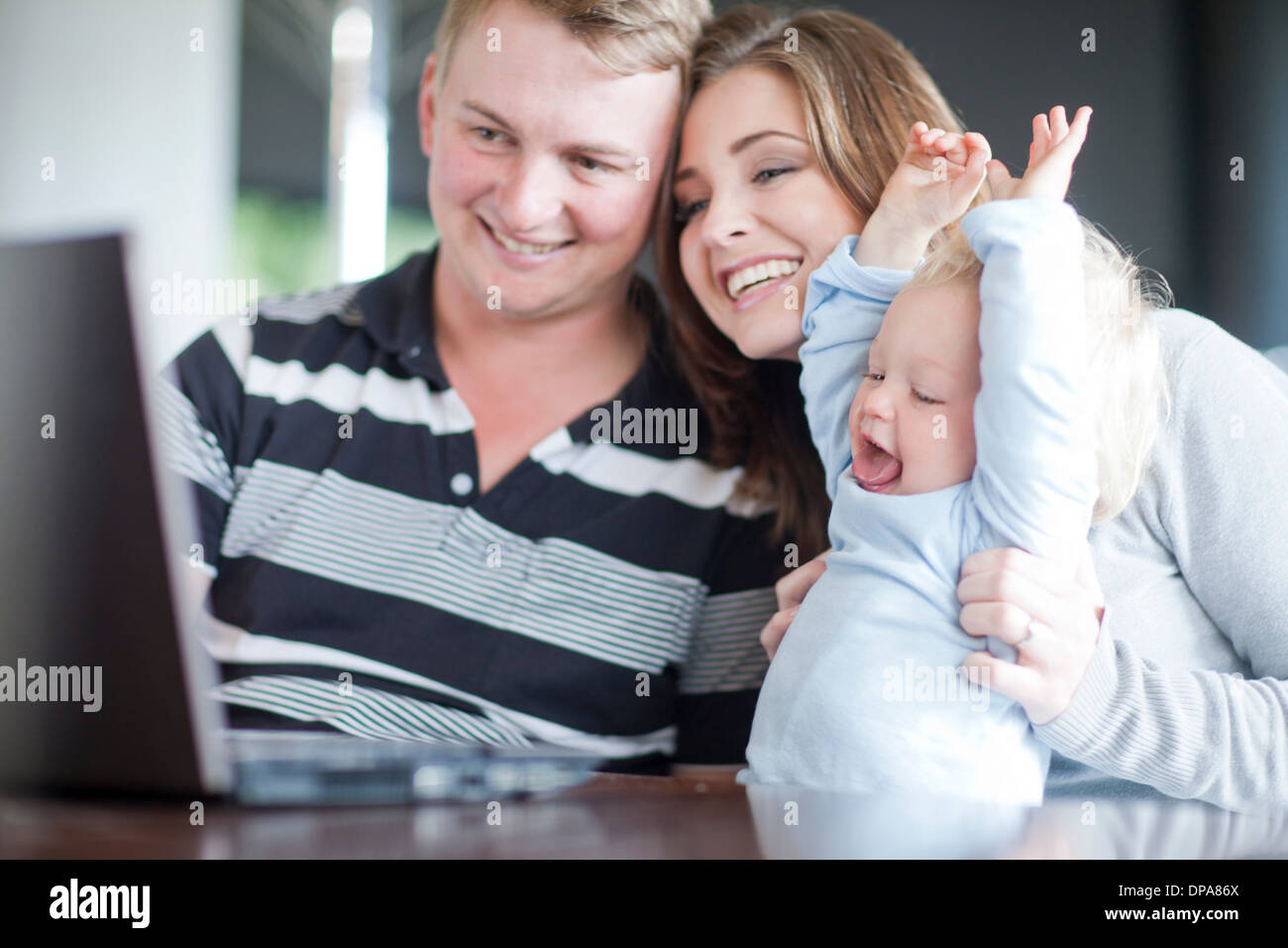 Mother and father with baby boy using computer Stock Photo - Alamy