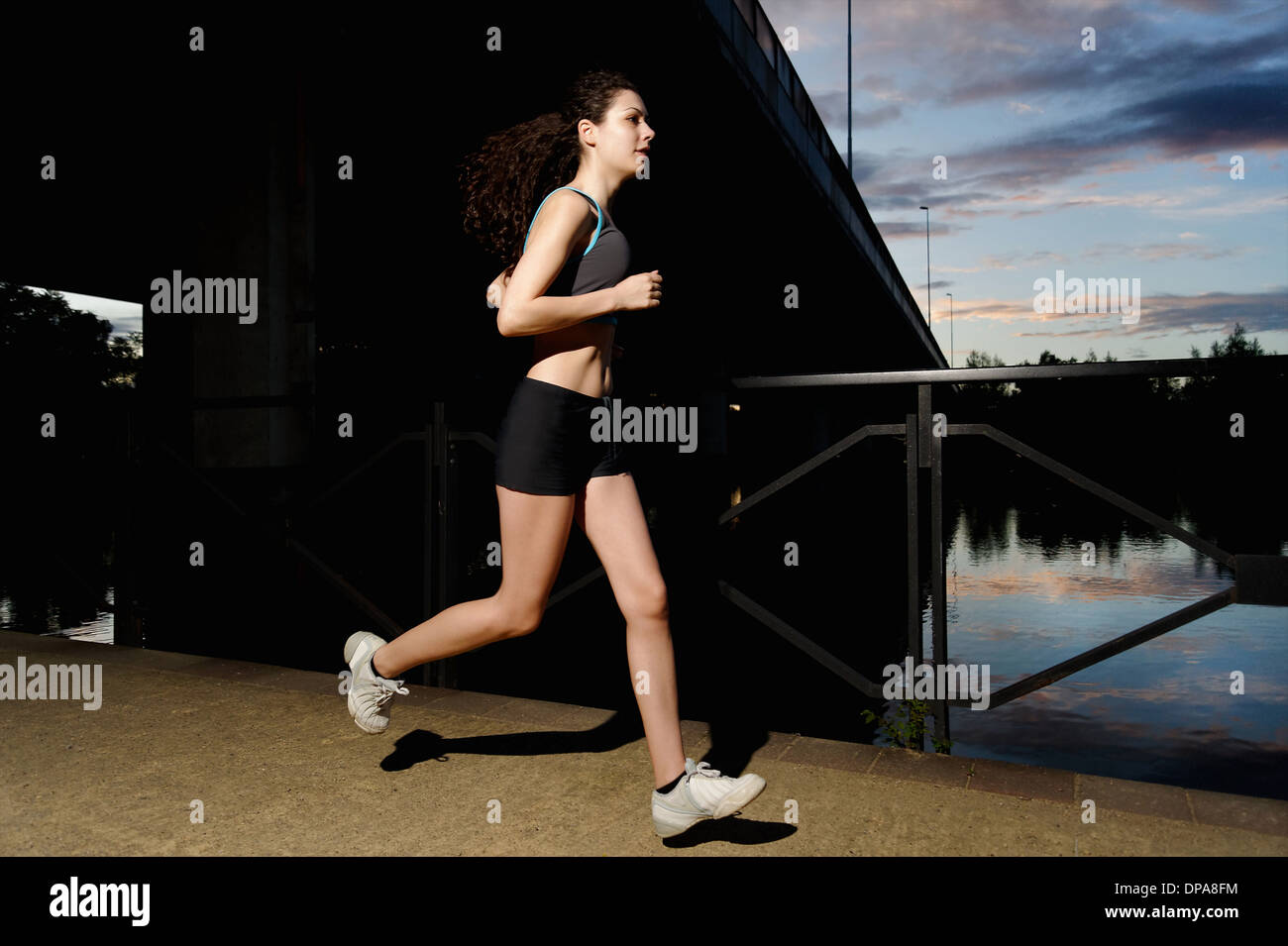 Young woman running outdoors on a lovely sunny summer evening (shallow ...