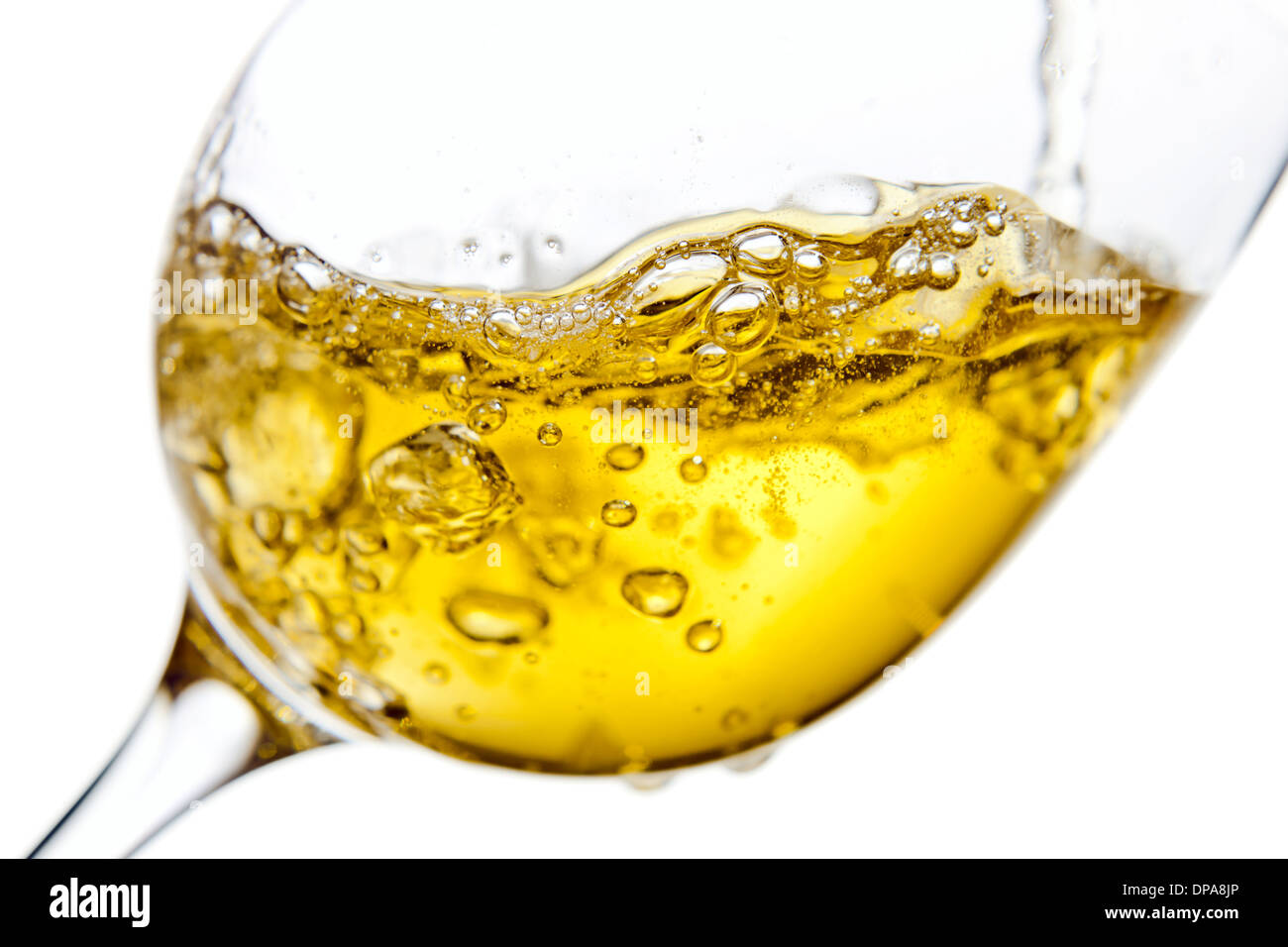 White wine being poured into a wineglass, isolated on white background ...
