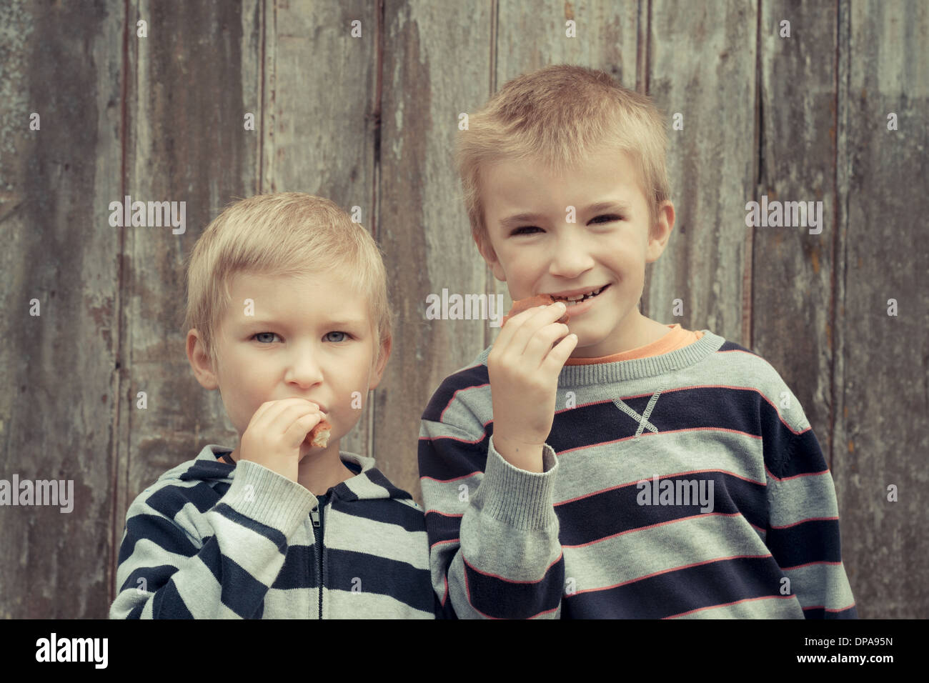 Portrait of brothers (4-5, 6-7) wearing stripe, eating Stock Photo - Alamy