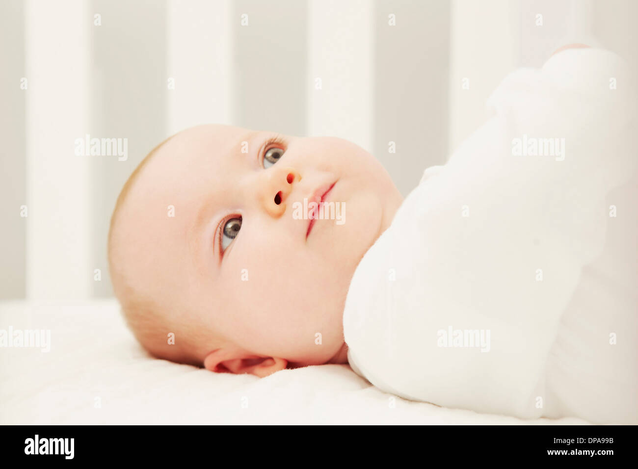 Baby in crib by herself Stock Photo - Alamy