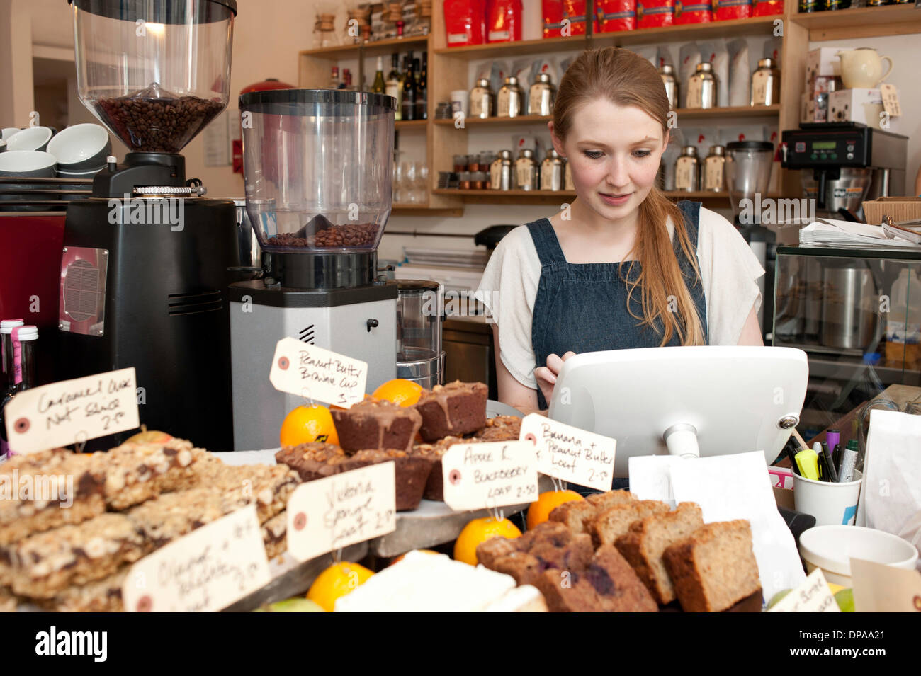 Young woman using cash register in cafe Stock Photo - Alamy