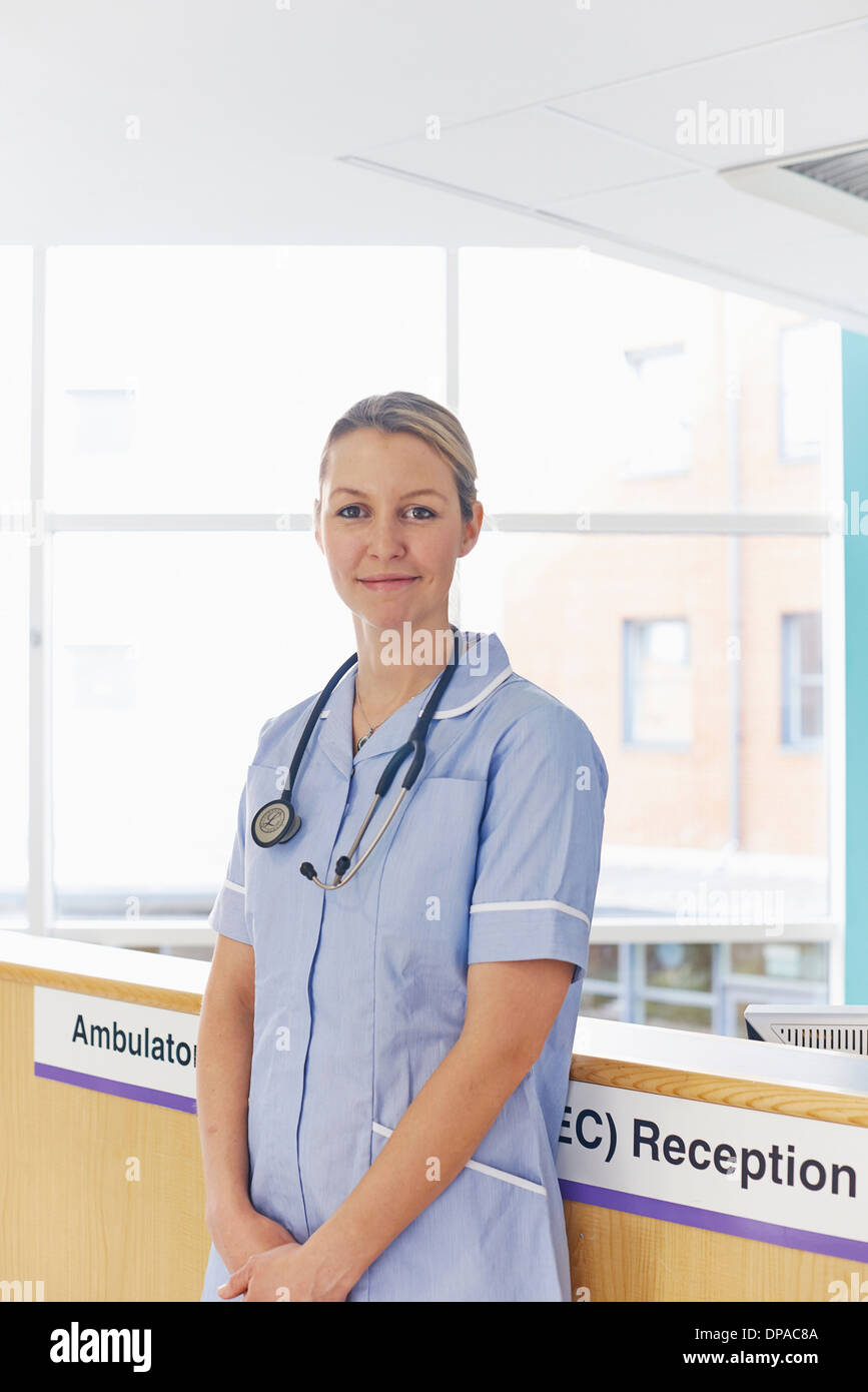 Nurse standing at reception desk Stock Photo - Alamy