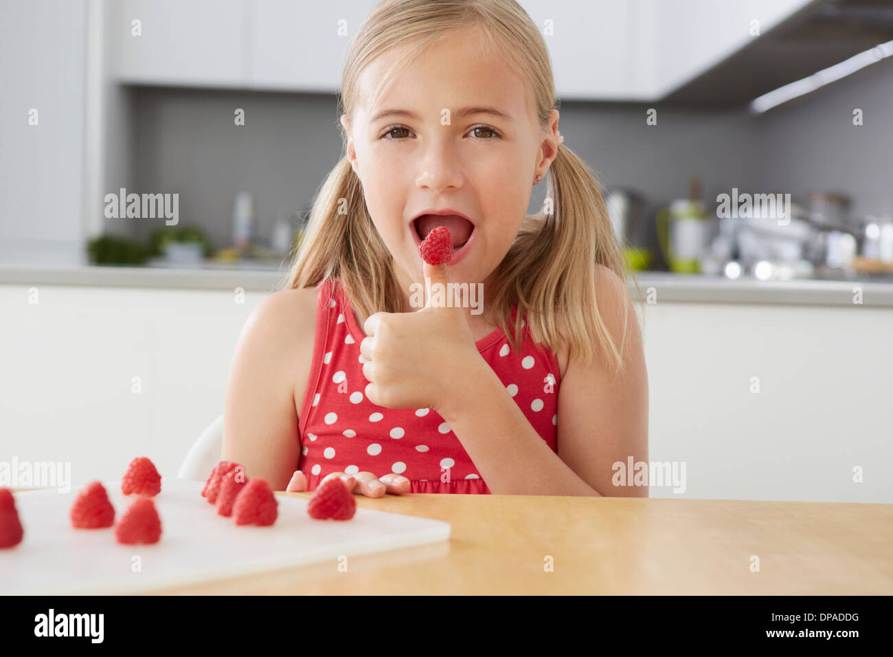 Girl eating raspberries from thumb Stock Photo - Alamy