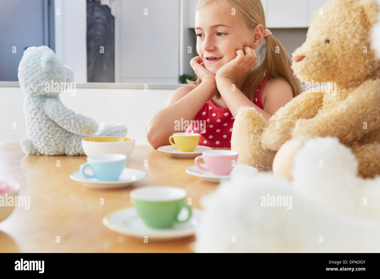 Girl having tea party with soft toys Stock Photo - Alamy