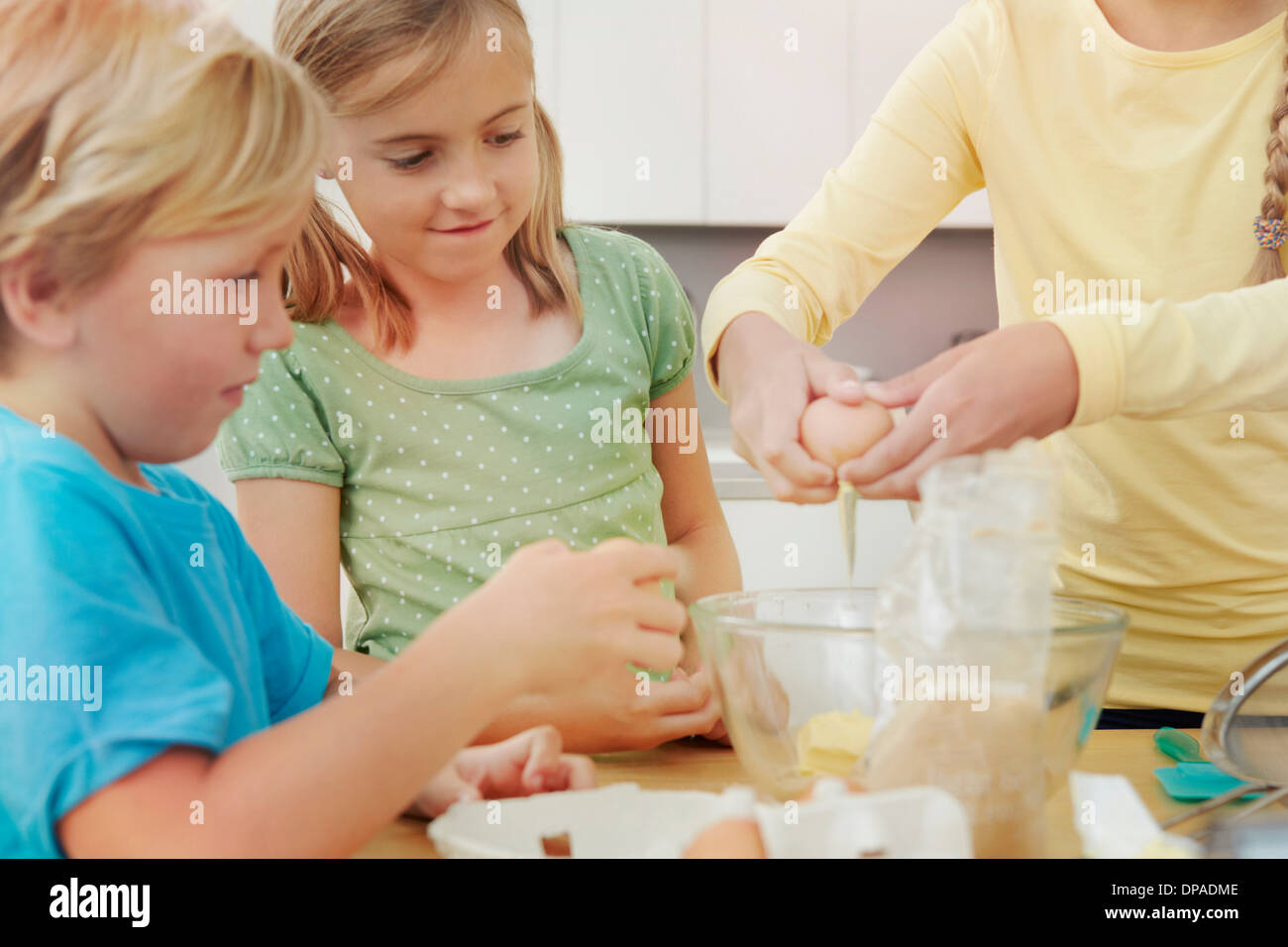 Children baking, breaking eggs into bowl Stock Photo - Alamy