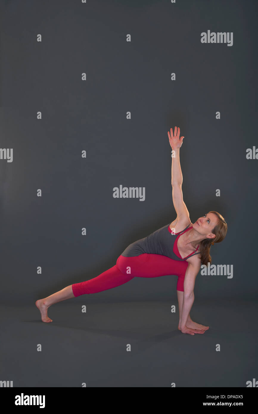 Woman in yoga pose on grey background Stock Photo - Alamy
