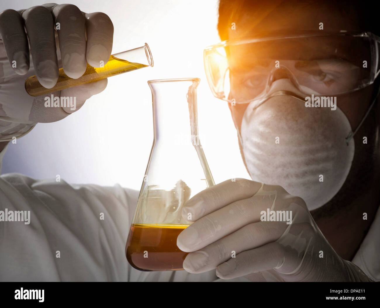 Close up of scientist pouring liquid into flask Stock Photo - Alamy