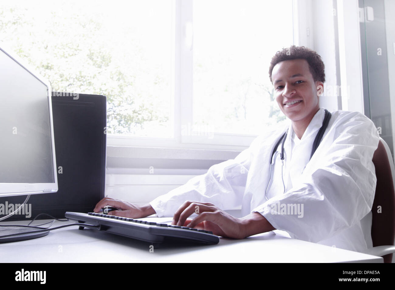 Scientist wearing lab coat working on computer Stock Photo - Alamy