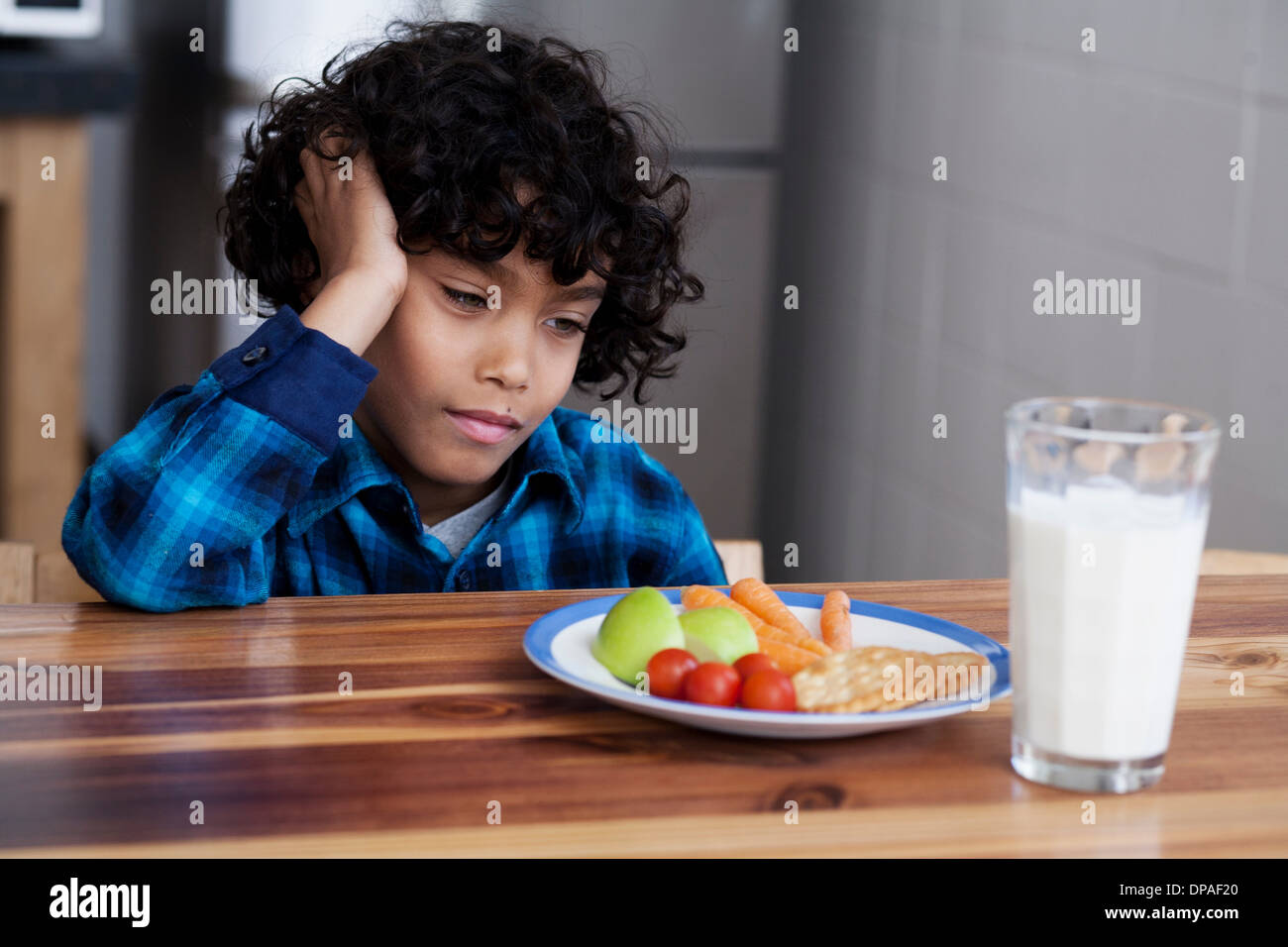 Boy staring at snacks and glass of milk Stock Photo - Alamy