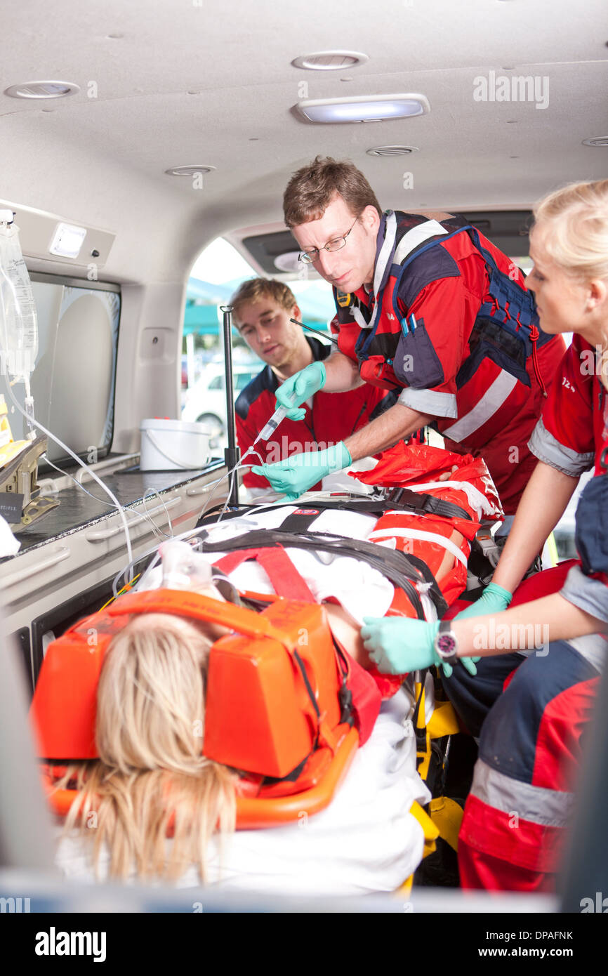 Paramedics with intravenous drip and patient in ambulance Stock Photo ...