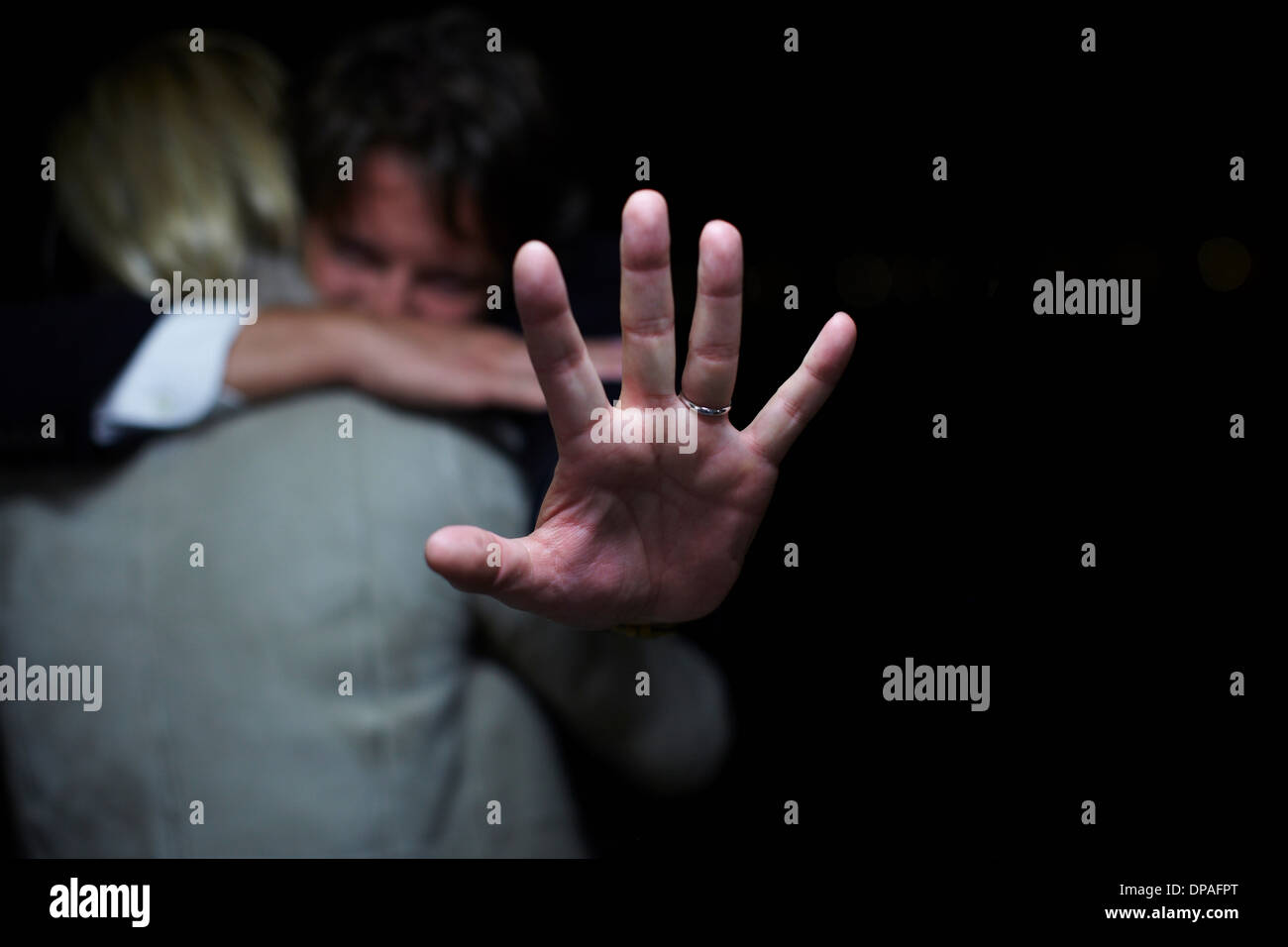 Mature man holding up hand whilst hugging woman Stock Photo - Alamy