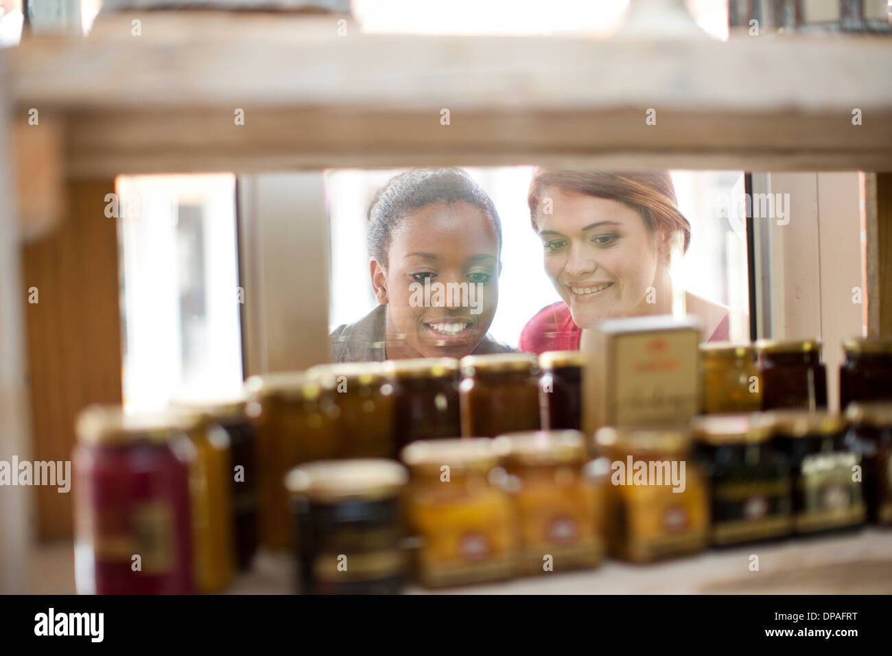 Two female friends looking through cafe window Stock Photo - Alamy