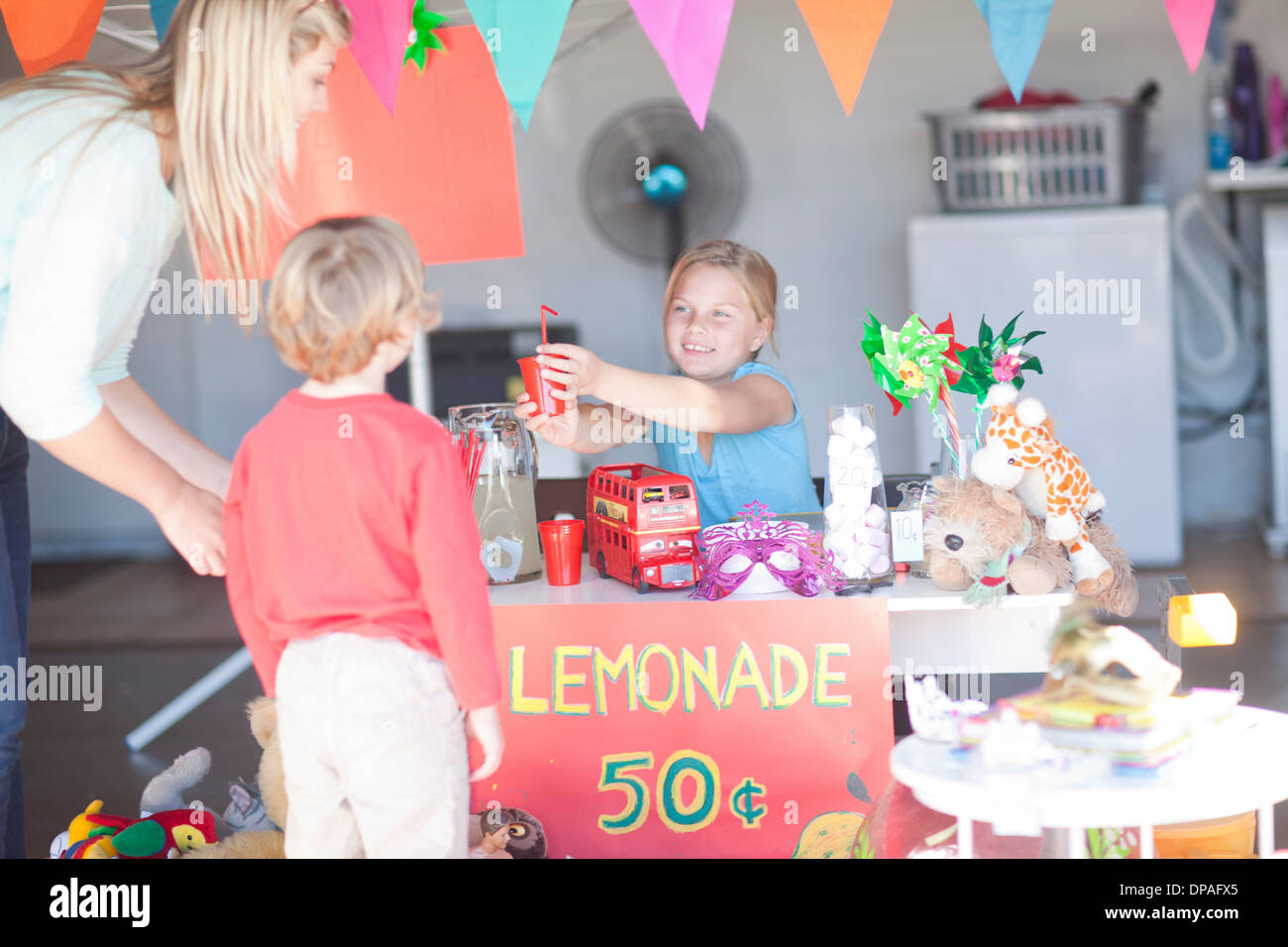 Two young sisters selling drink to mother from stall Stock Photo - Alamy