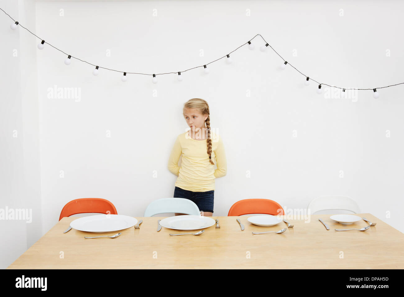 Girl waiting by table with empty plates Stock Photo - Alamy